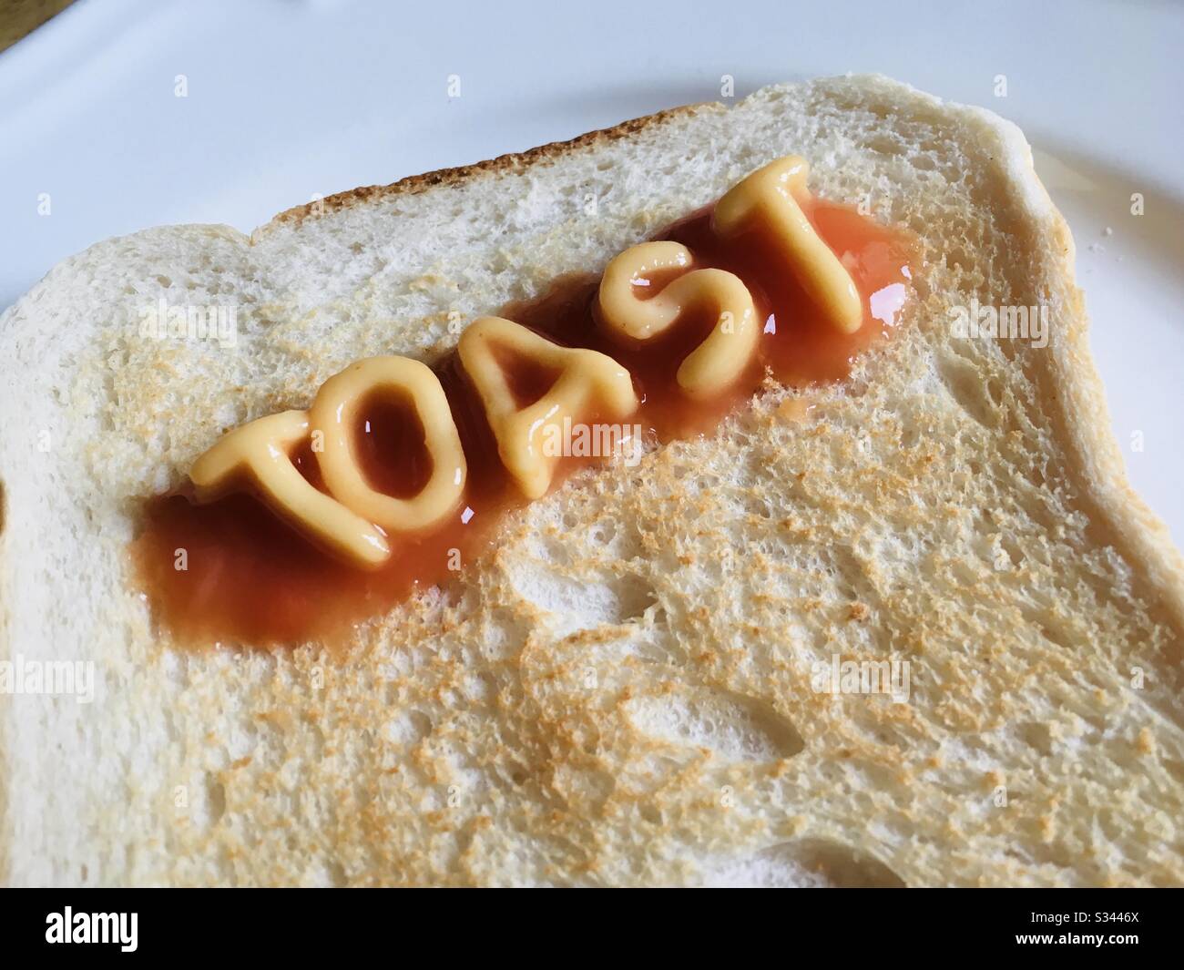 Slice of toast with alphabet spaghetti saying toast Stock Photo - Alamy