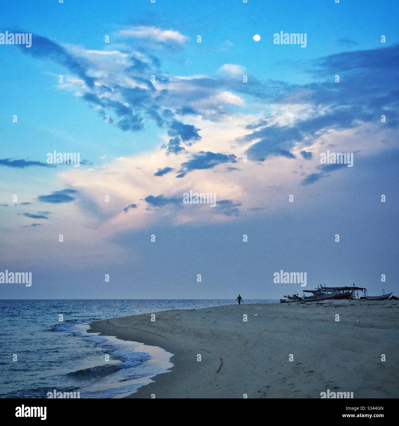 Thunderstorm and full moon over the beach at twilight in Batu Rakit ...