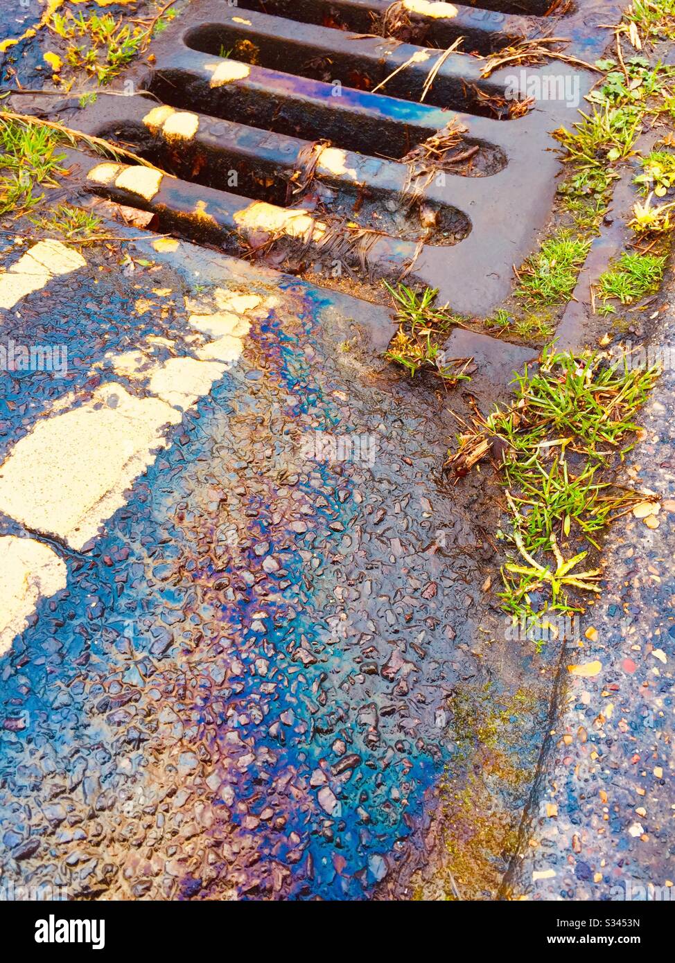 Petrol oil rainbow running into a drain pollution Stock Photo - Alamy