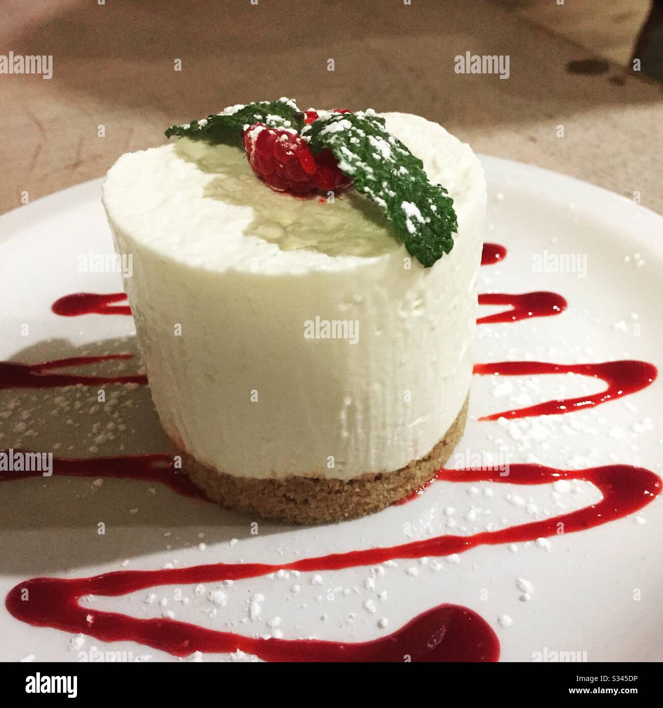 Lemon cheesecake with raspberry coulis Stock Photo - Alamy