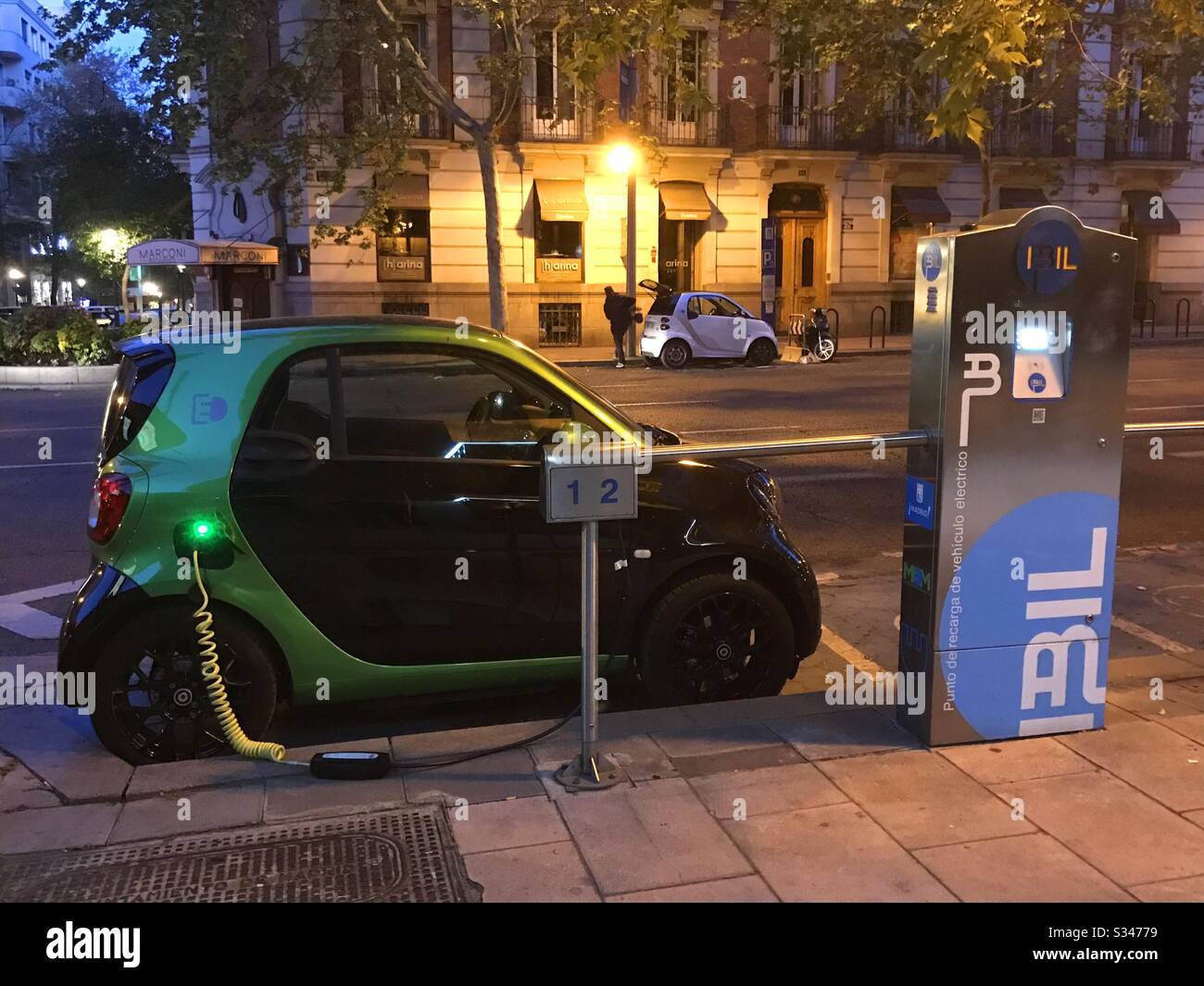 Electric car recharging its battery in the street Stock Photo - Alamy