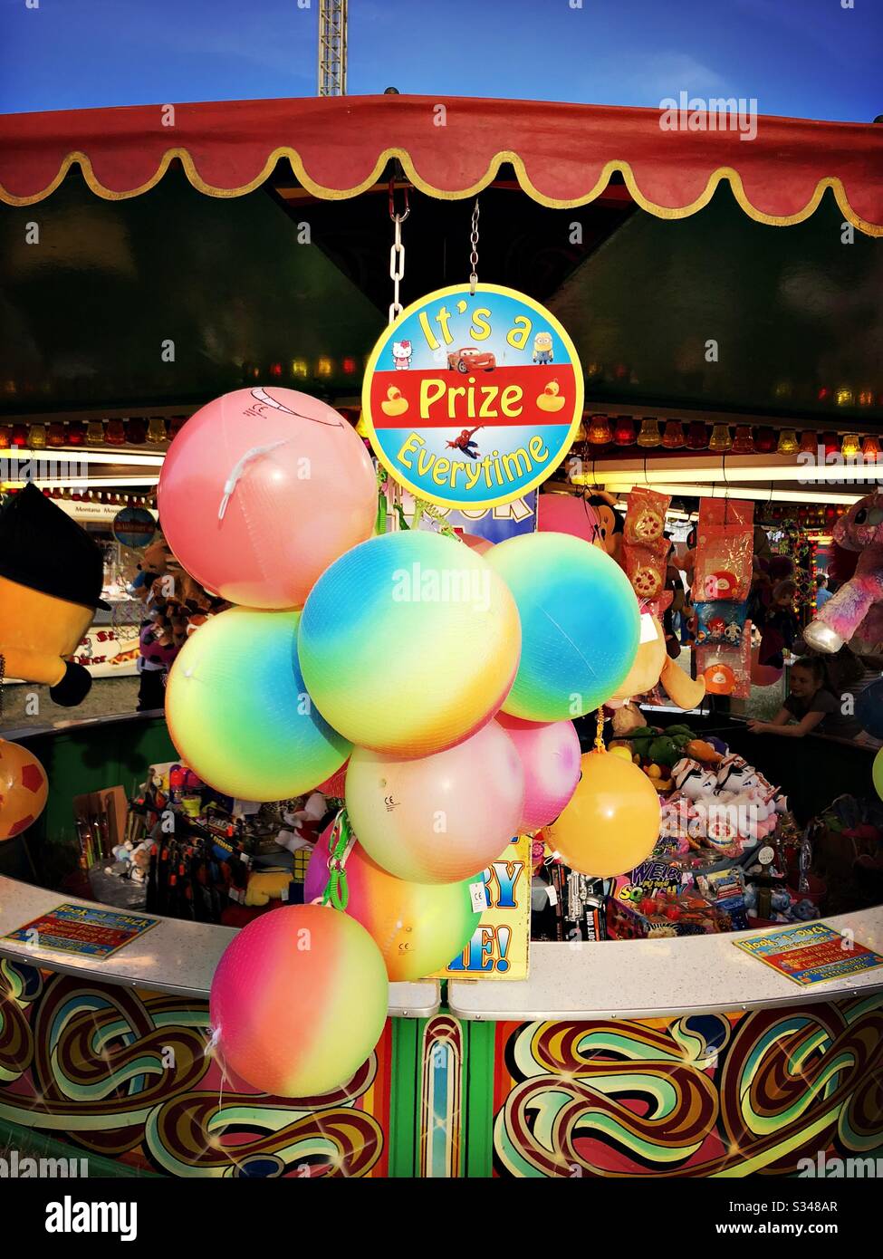 Colorful sign and multicolored balls are seen hanging at a fairground ...