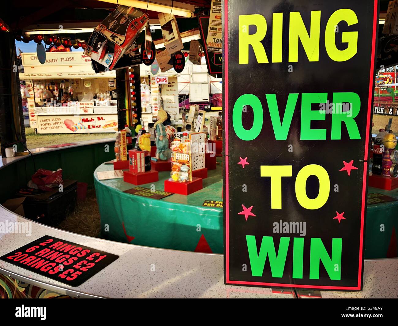 Ring over to win sign at a fairground stand with colourful prizes in ...