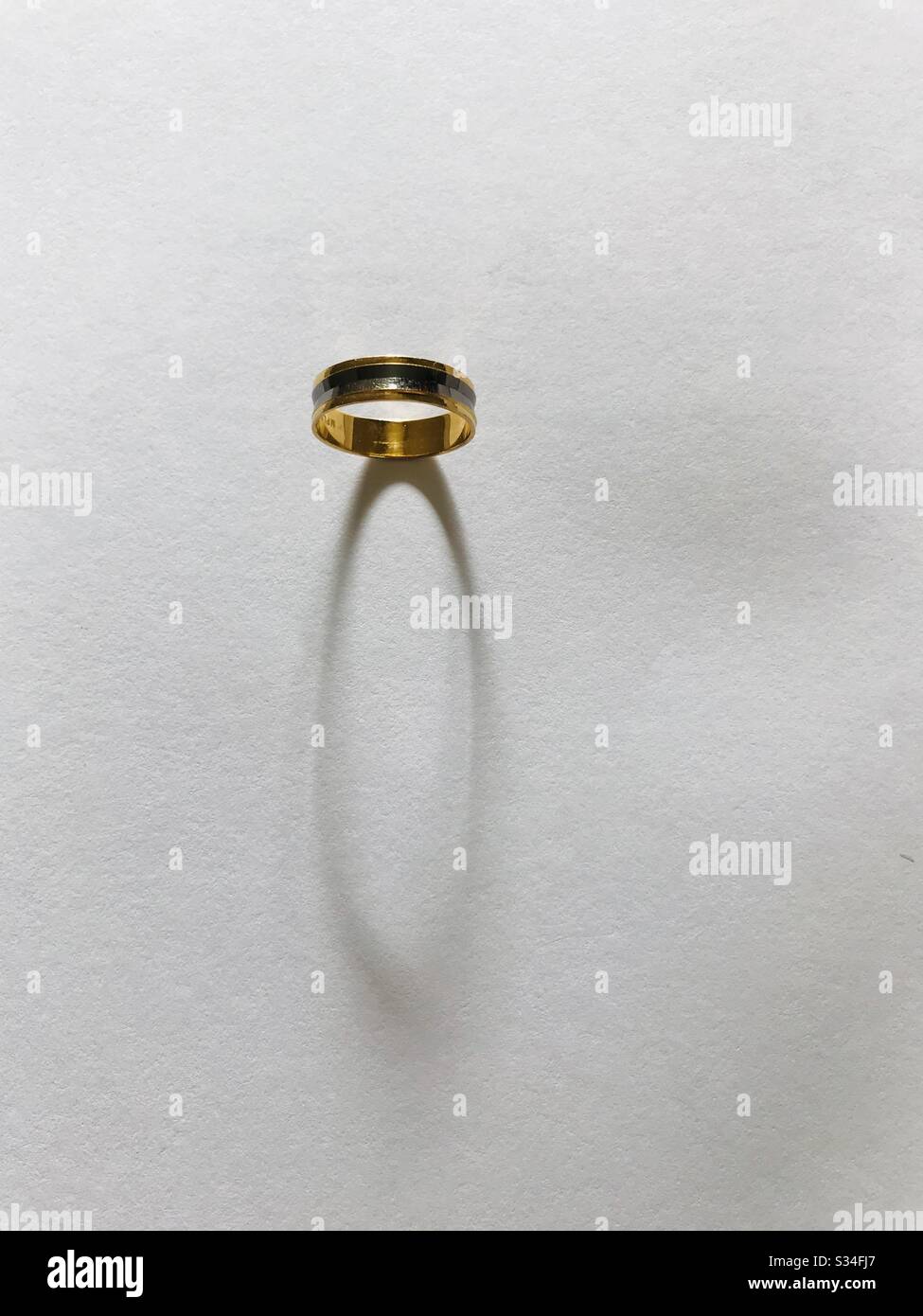 Gold ring placed on white background against sunlight , it was glowing ...