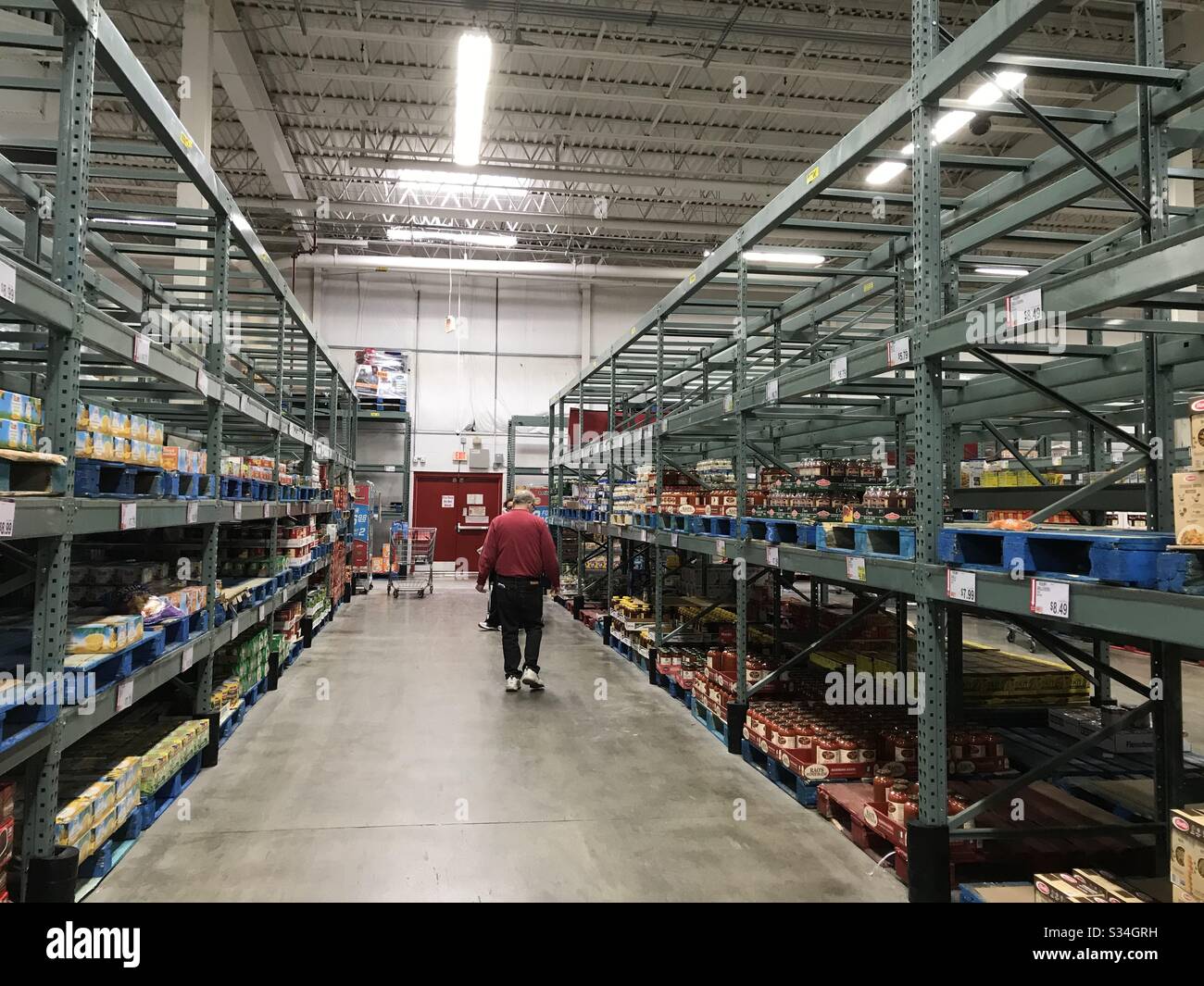 People shopping in half empty food shelves in club supermarket during ...