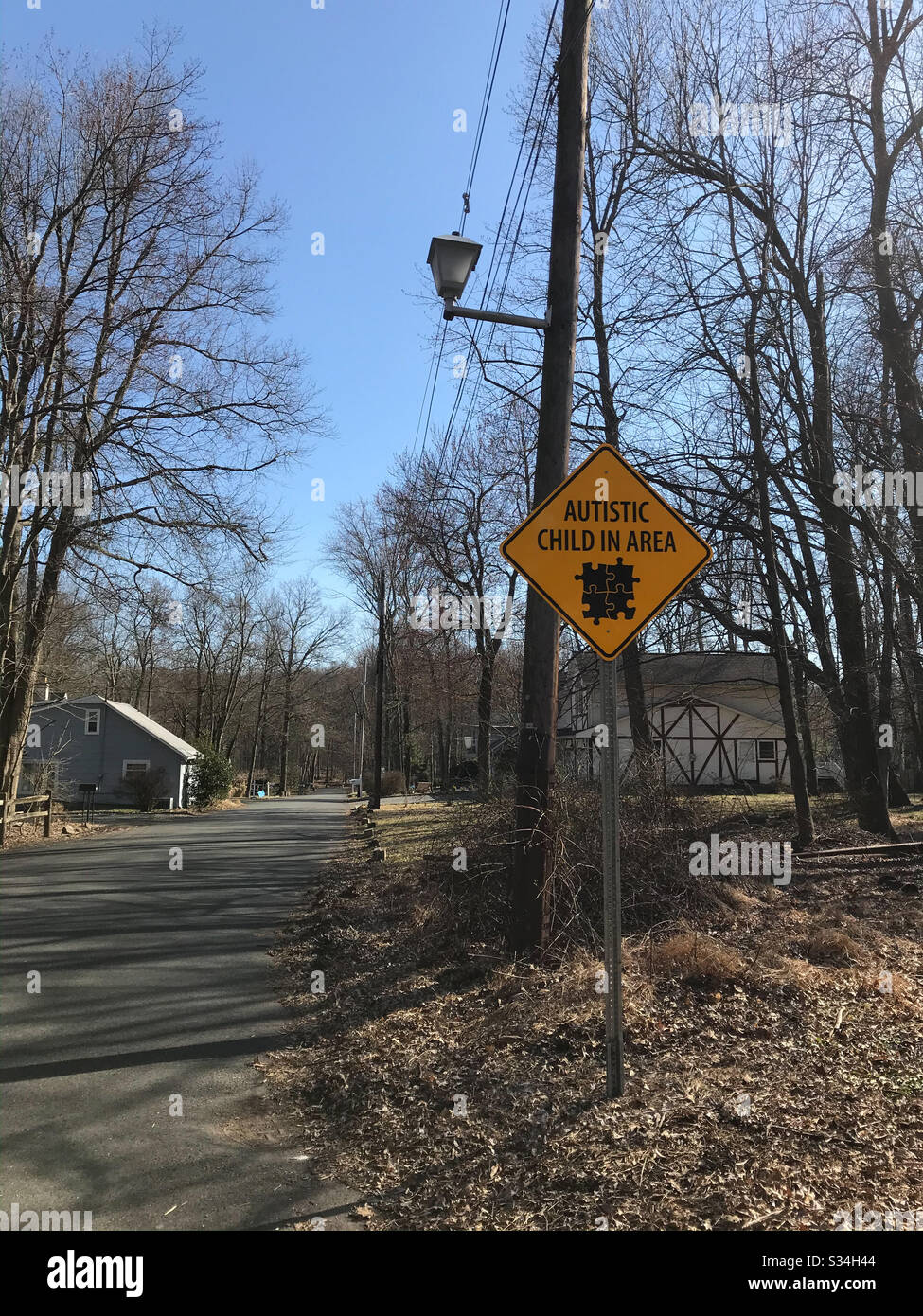 Autistic child in area road sign in suburban town in the American North ...