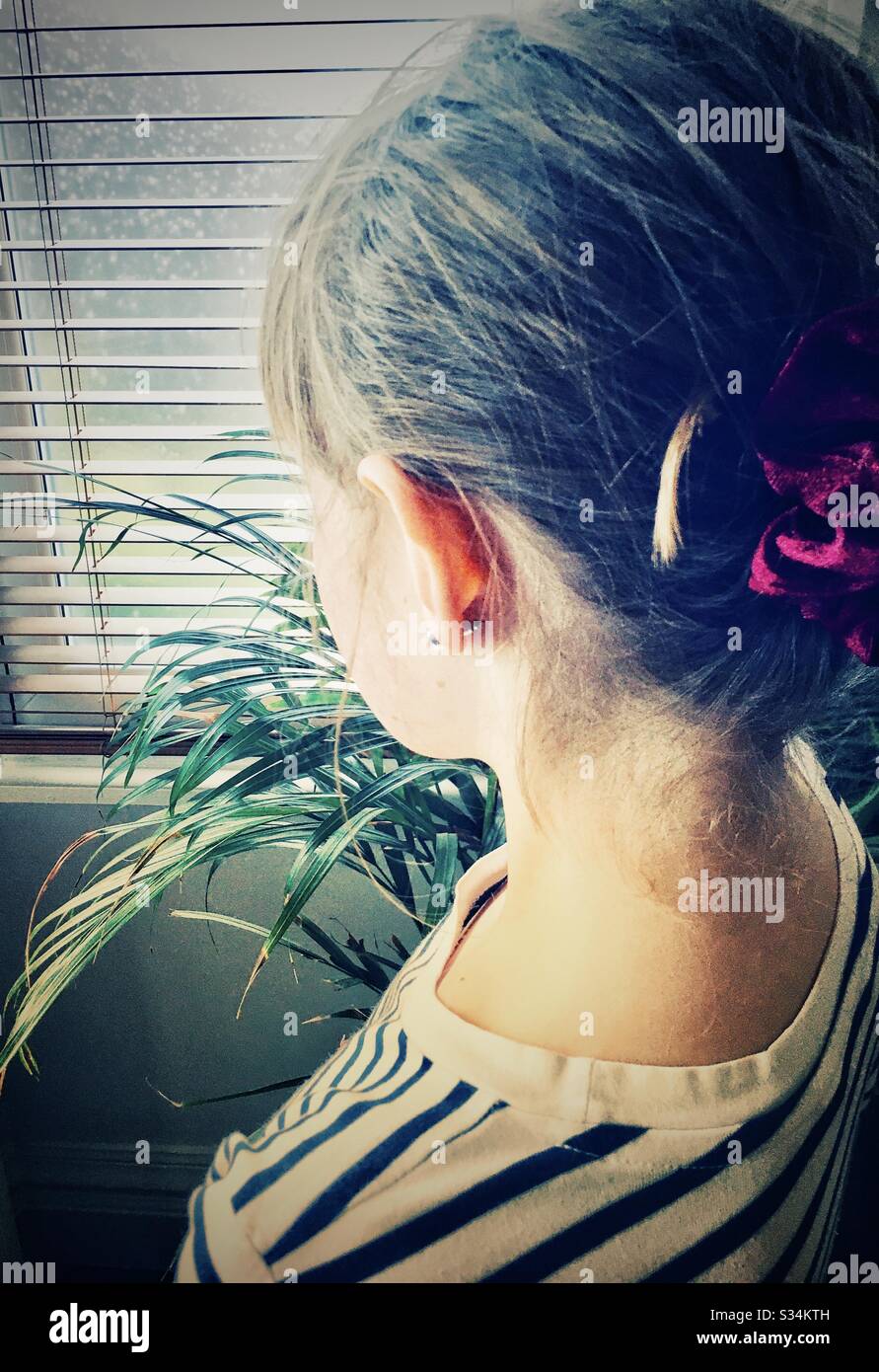 Girl looking out of window Stock Photo - Alamy
