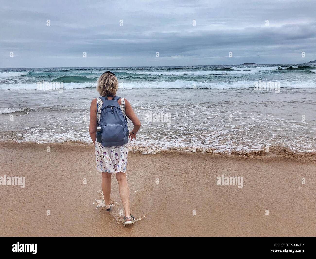 Woman walking into the sea Stock Photo - Alamy