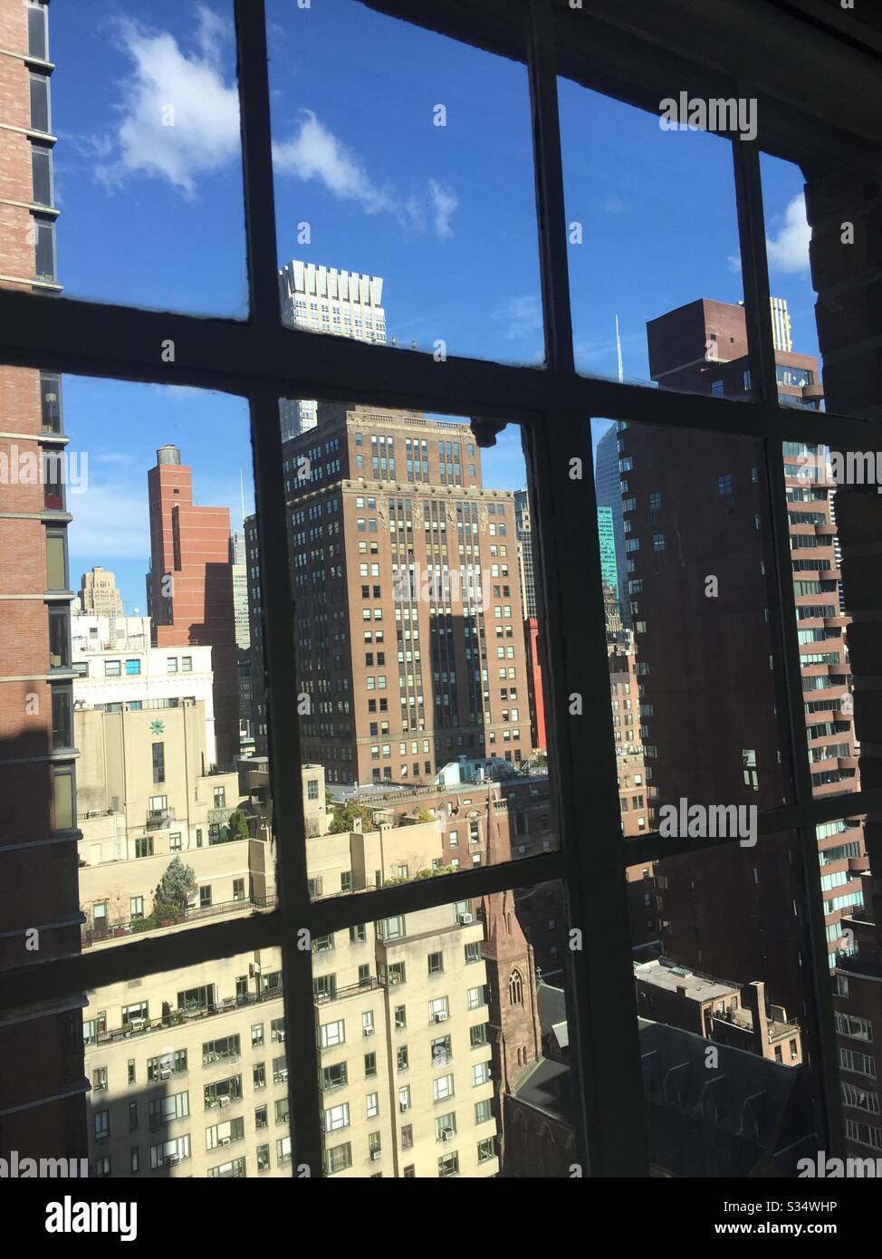 Midtown Manhattan skyscrapers as seen from a an apartment with casement ...