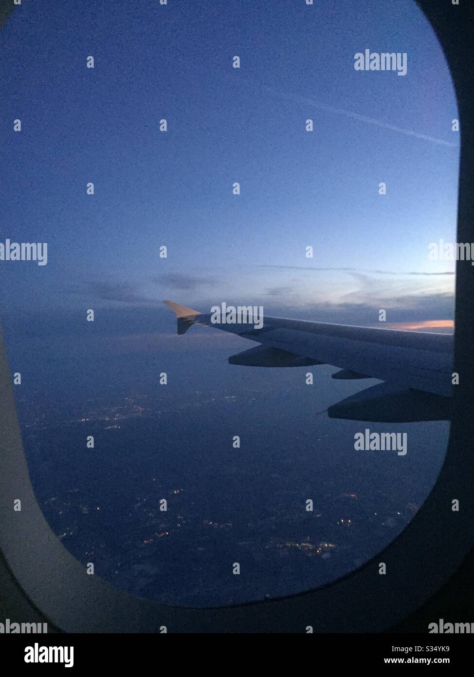 Plane window looking out on a sunset Stock Photo - Alamy