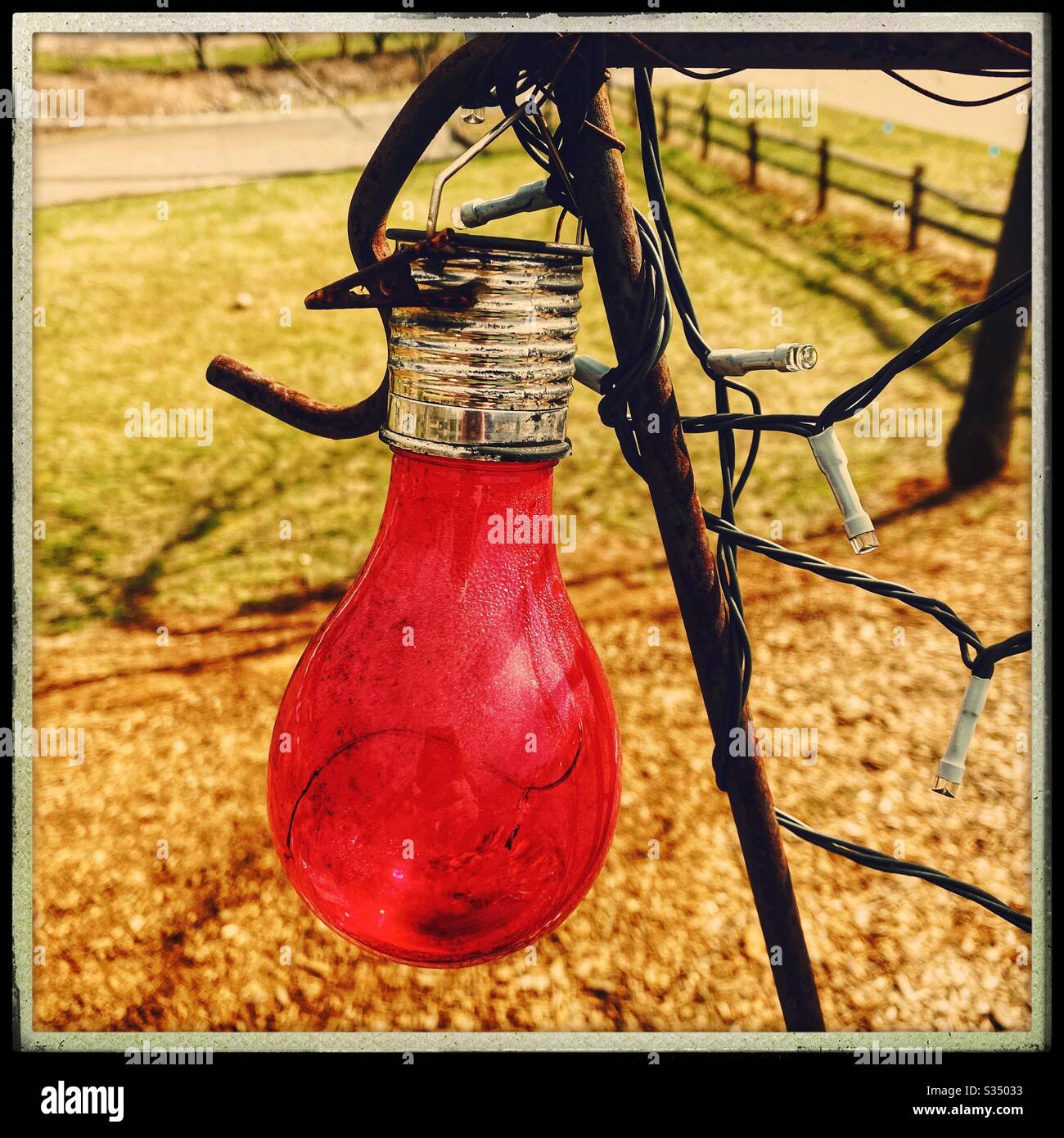 Red light bulb hanging from the fence Stock Photo - Alamy
