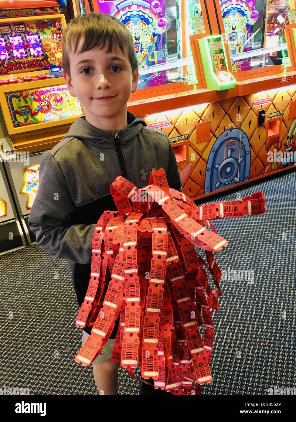 Boy winning tickets at amusement arcade Stock Photo - Alamy