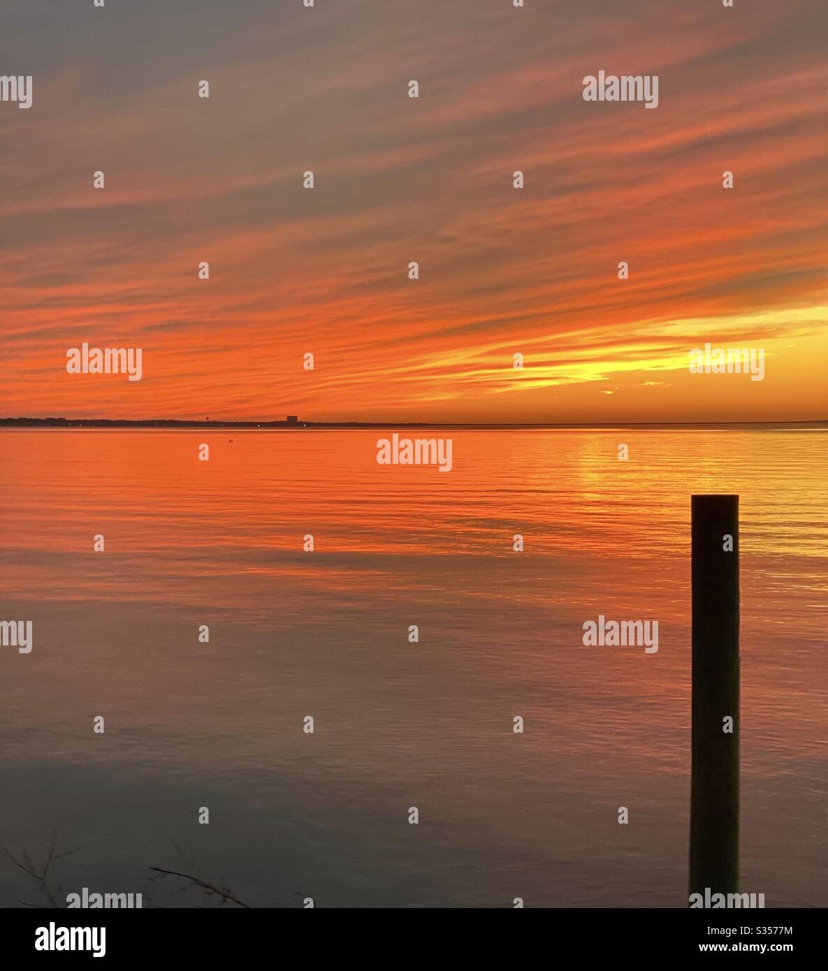 Sunset over the Choctawhatchee Bay in a burst of bright orange color ...