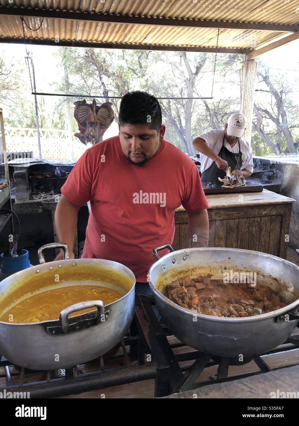 Two chefs working in an outdoor kitchen Stock Photo - Alamy