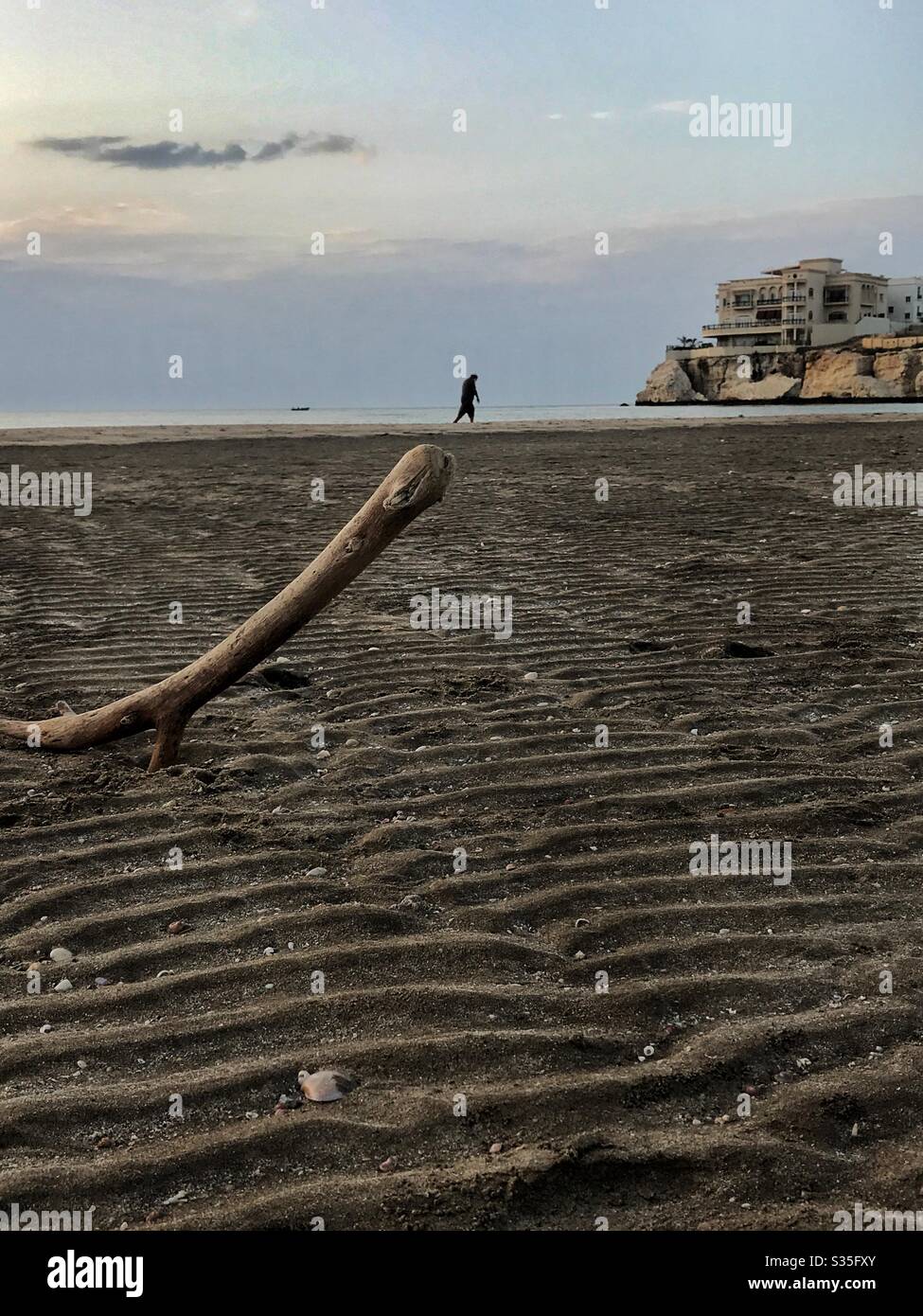 A sad man walking alone along the empty beach Stock Photo - Alamy