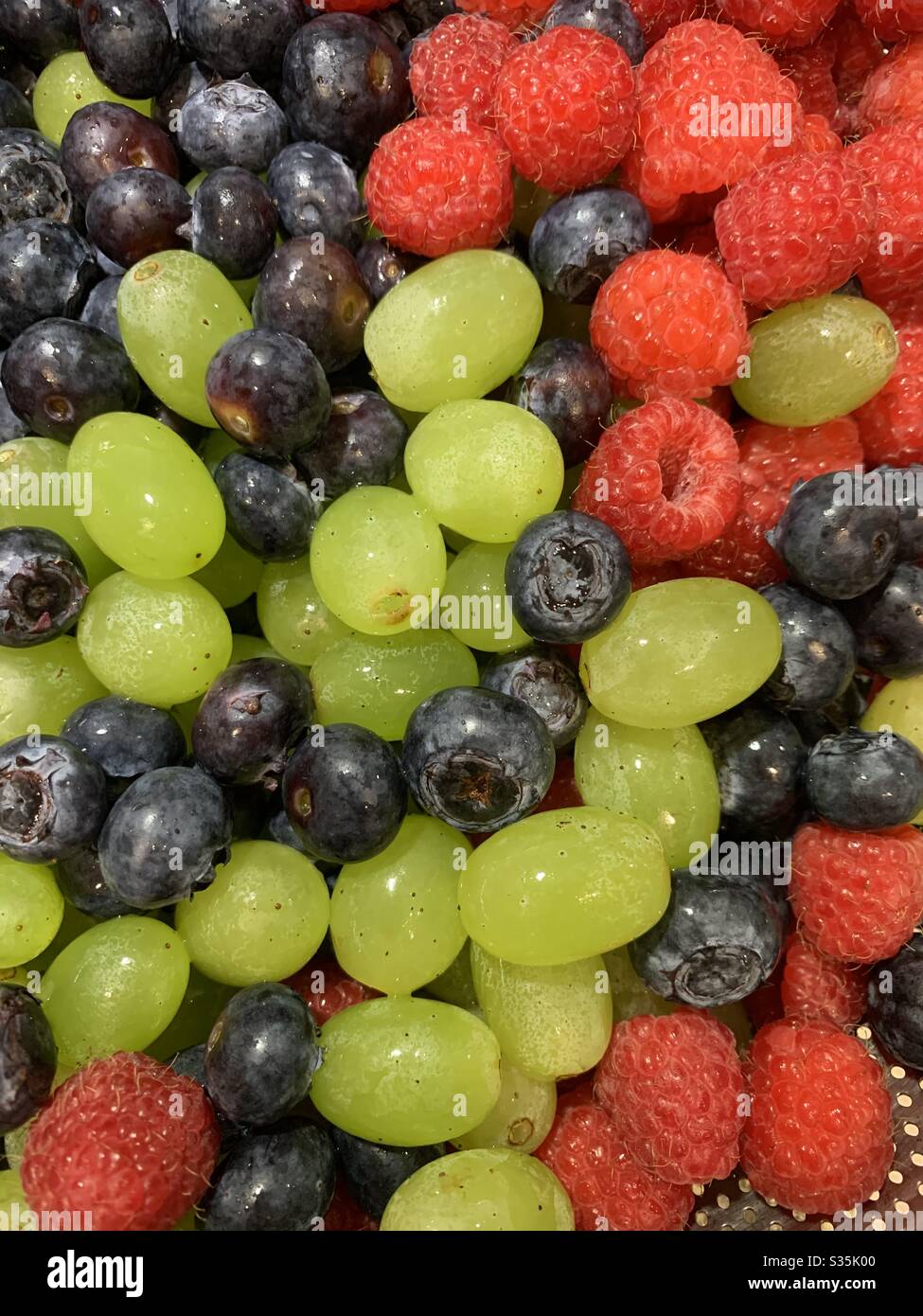 Fresh fruit salad: Green grapes, Raspberries and blueberries in a ...