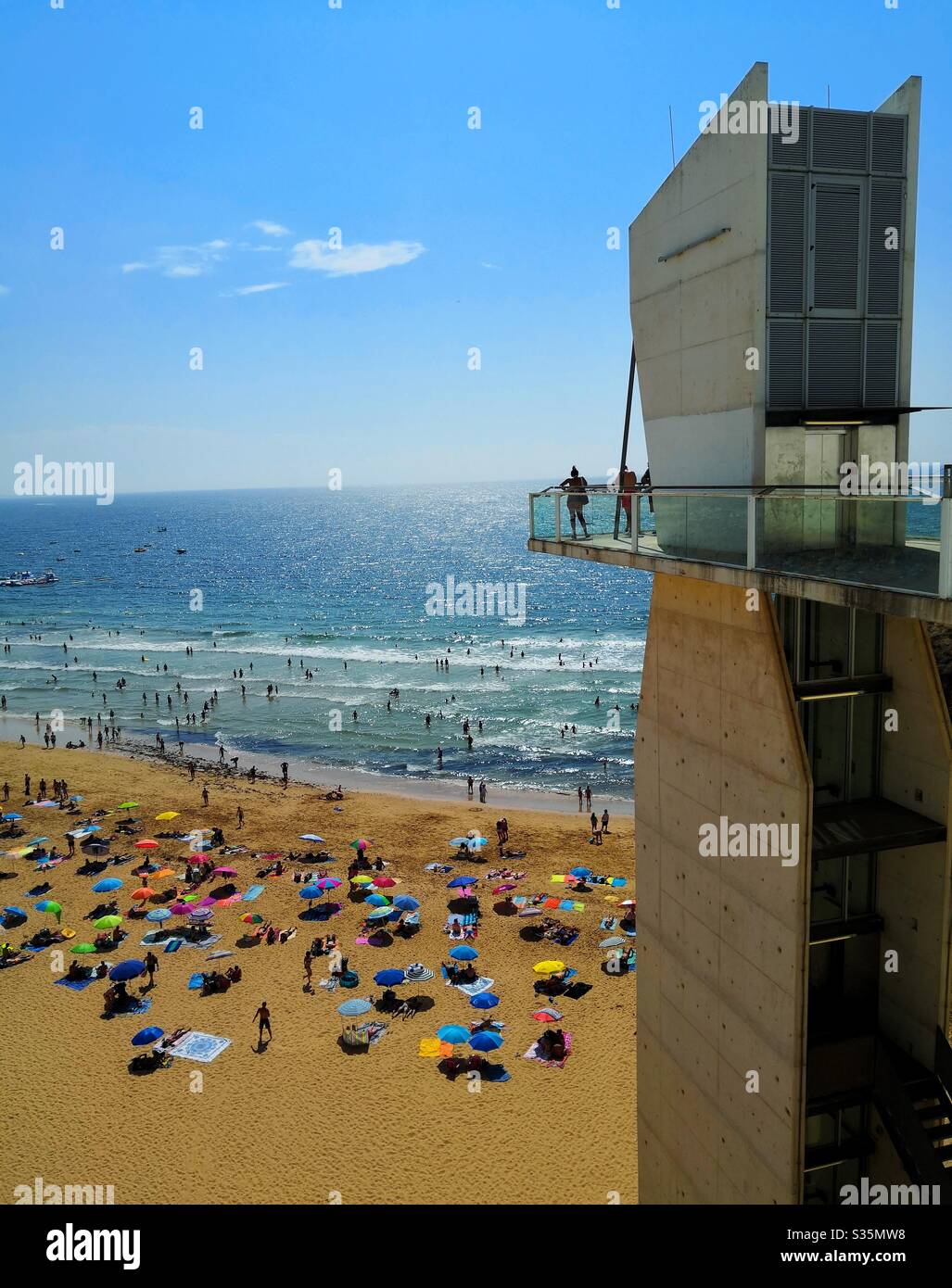 View point looming over people bathing on a beach on the ocean Stock ...