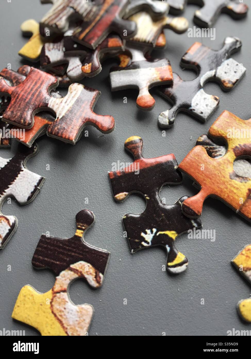 Still life of interlocking puzzle pieces in an incomplete puzzle Stock ...