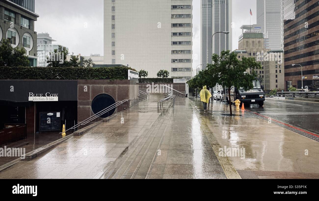 LOS ANGELES, CA, APR 2020: man in yellow raincoat walking along S Grand ...