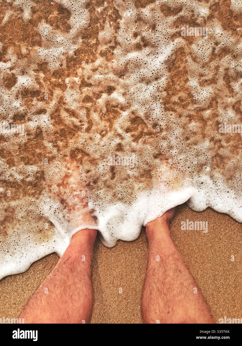 Seawater rushing over the feet on the beach Stock Photo - Alamy