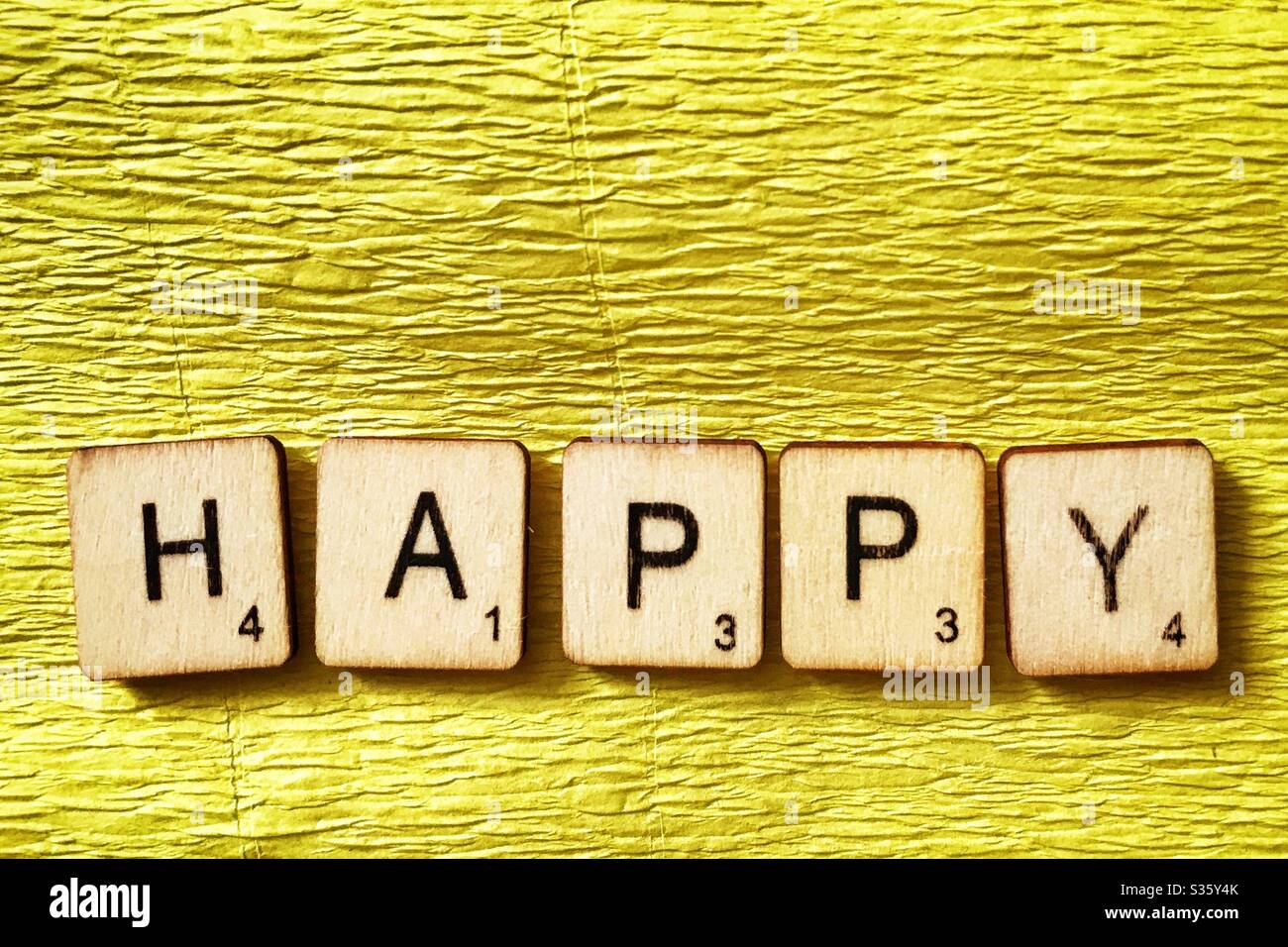 Wooden tiles spell out Happy Stock Photo - Alamy