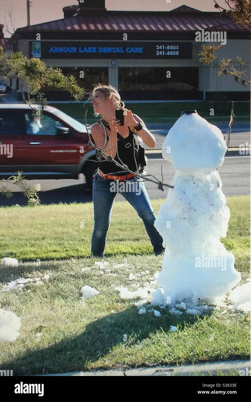 Lady taking a photo of a Snowman in summer Stock Photo - Alamy