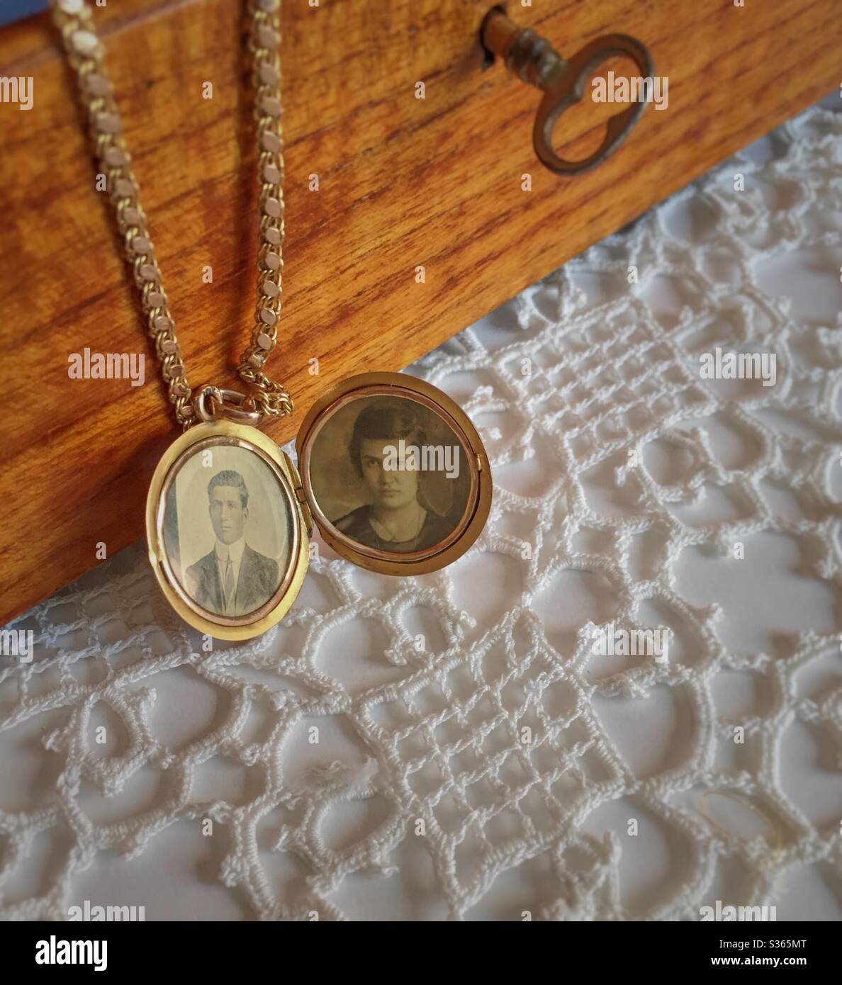 Antique photo locket hanging from handcrafted vintage wooden jewelry ...