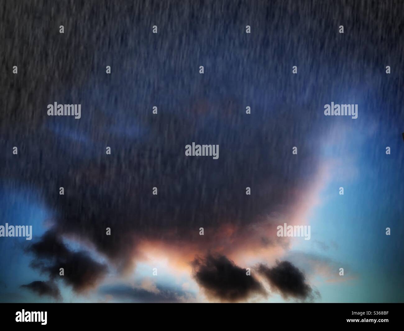 The rain falling down from the dramatic and colourful clouds Stock ...