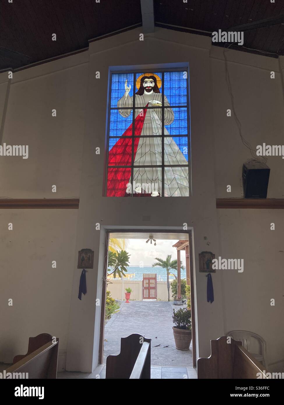 View of stained glass and the Caribbean Sea out the door of the San ...