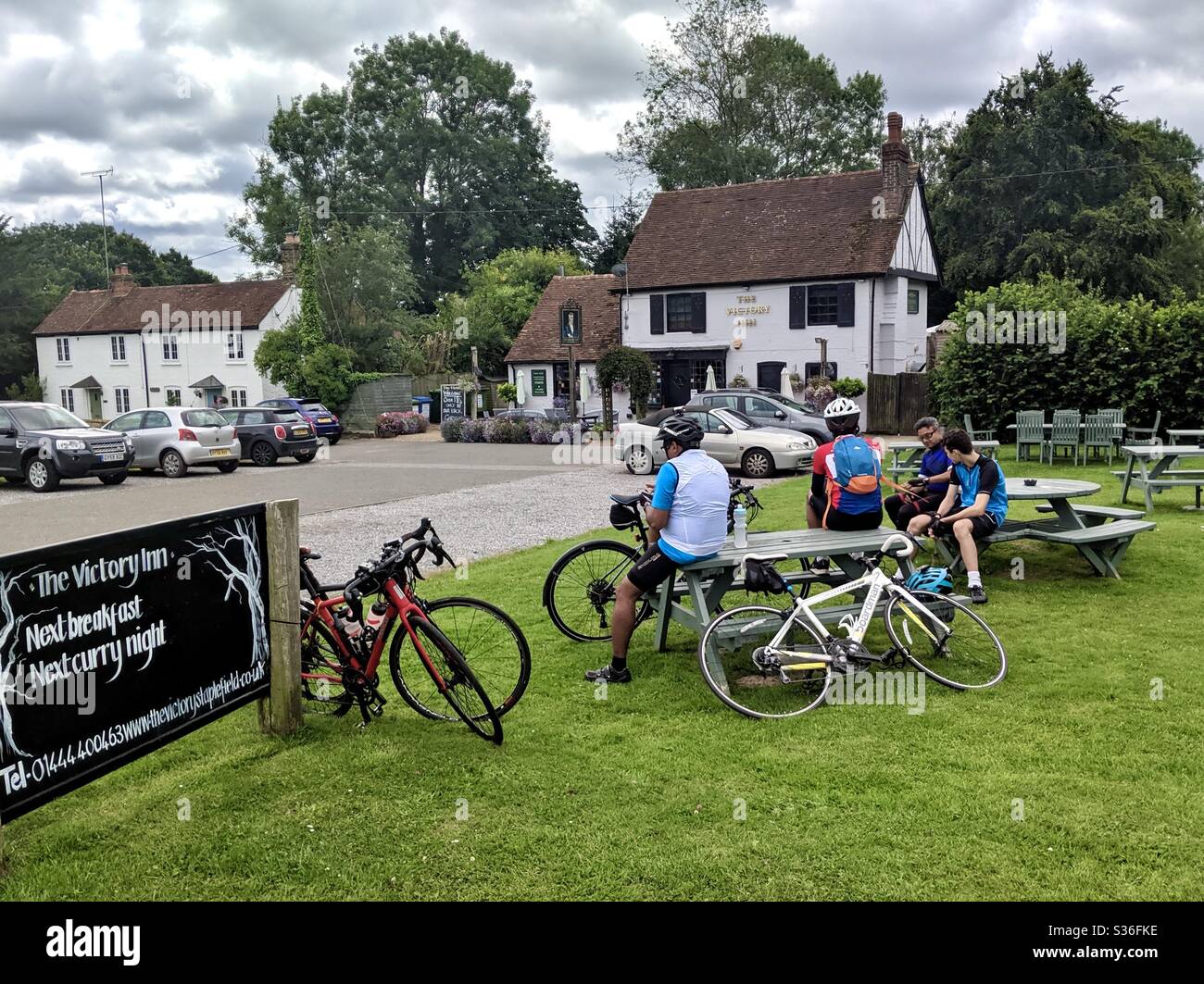 Small cycling group relaxing at a pub outdoor seating Stock Photo - Alamy