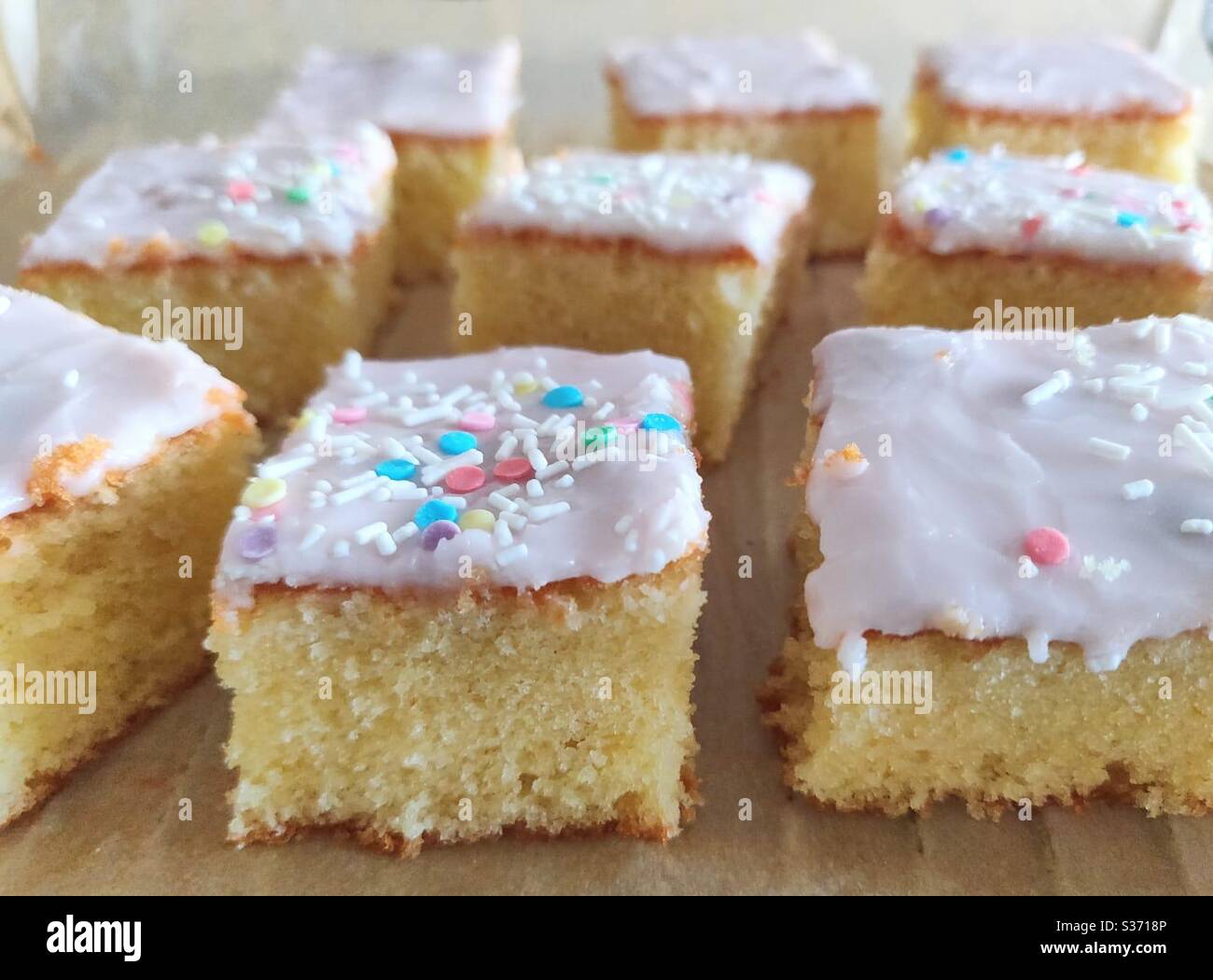Tray bake sponge cakes topped with icing and sprinkles Stock Photo - Alamy