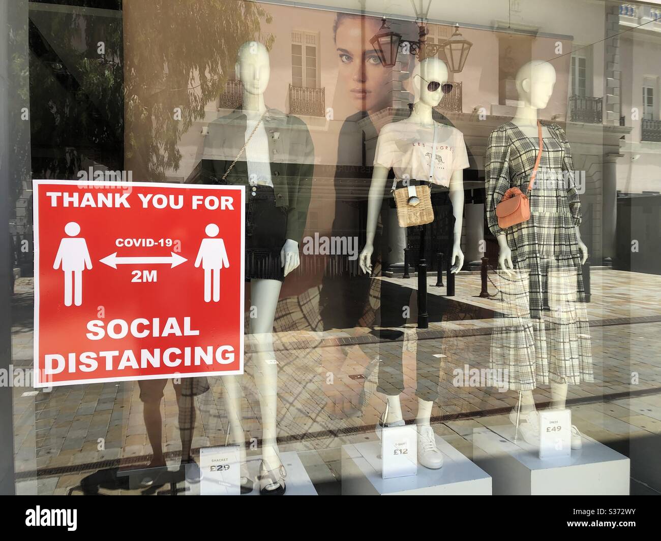 Social distancing sign on the glass window display on a branch of Top ...