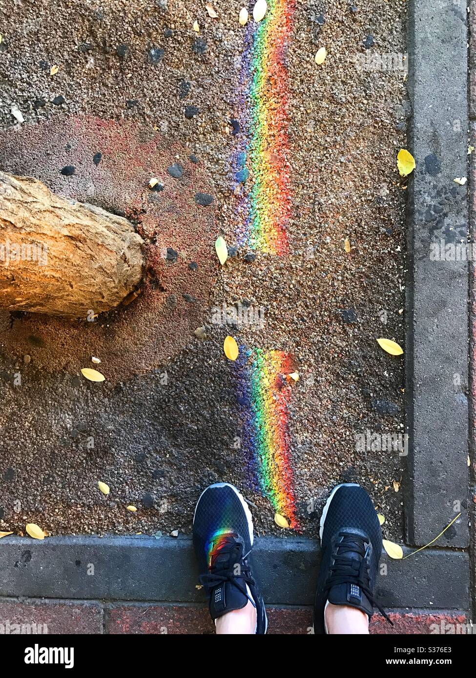 Rainbow reflected on ground and feet wearing sneakers Stock Photo - Alamy
