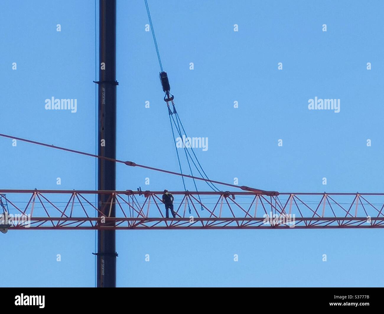 Man walking on arm of crane Stock Photo - Alamy