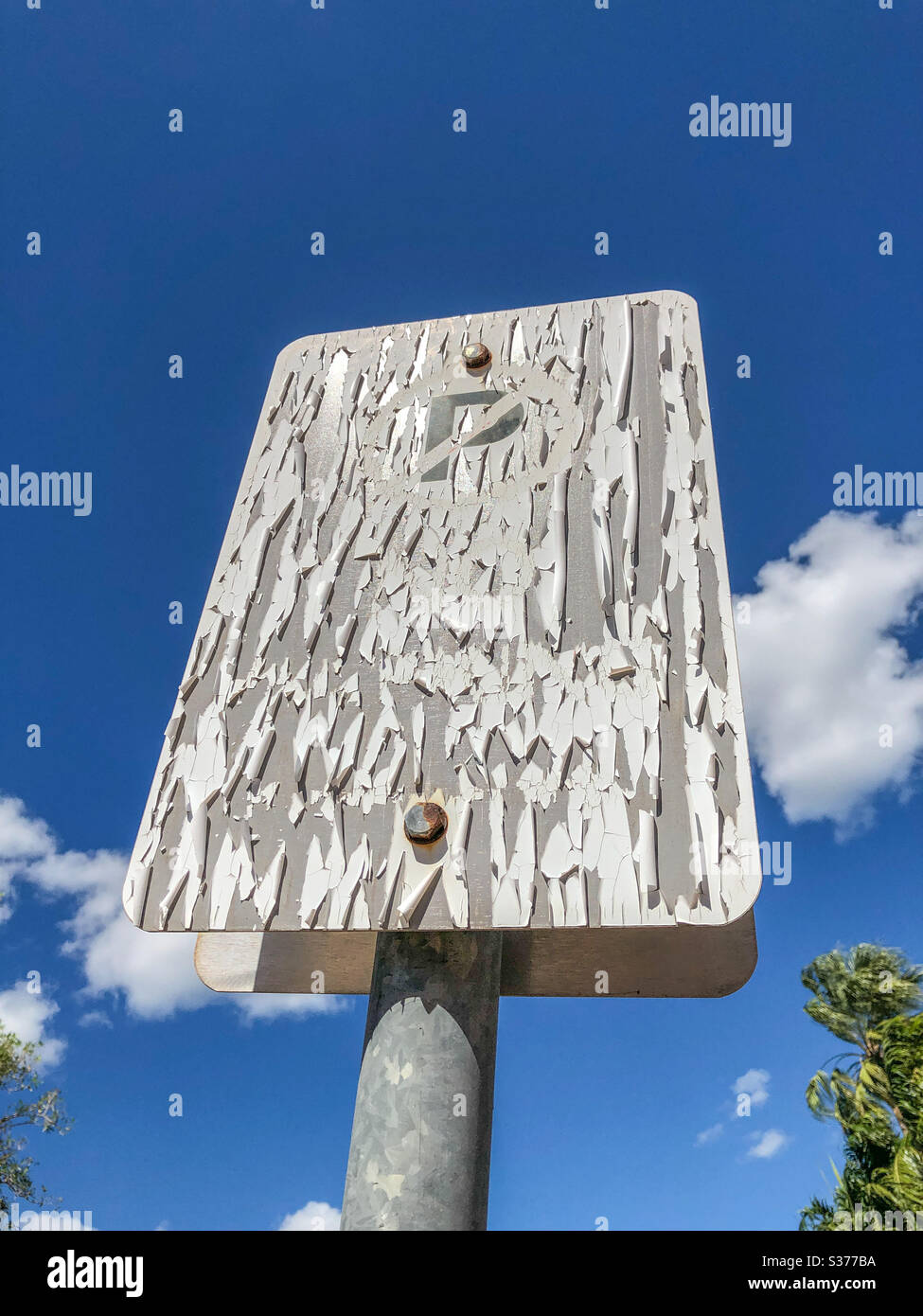 Sun damaged no parking sign against blue sky Stock Photo - Alamy
