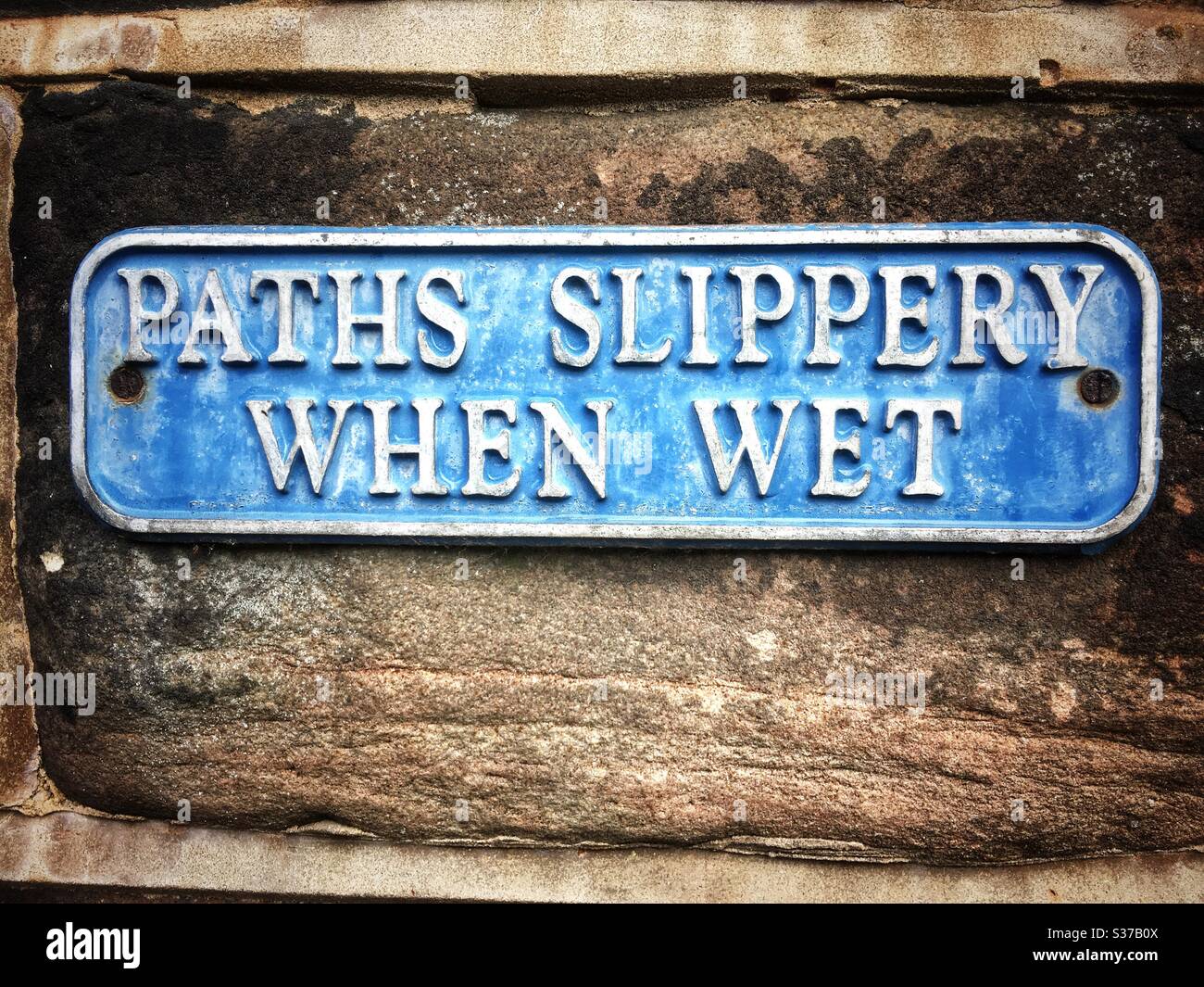 Paths slippery when wet warning sign Stock Photo - Alamy