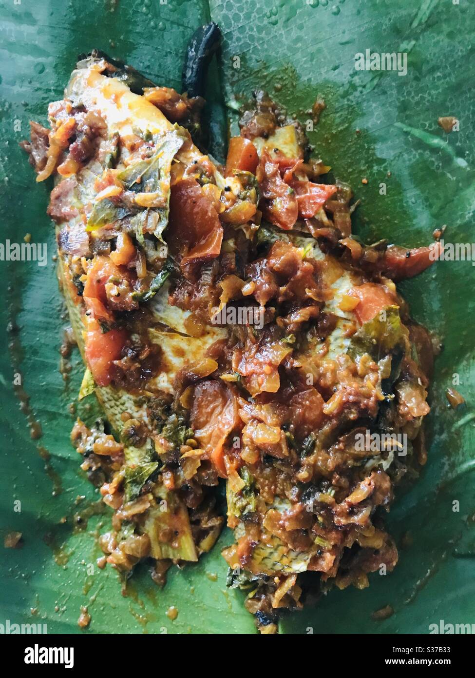 Raw Yellow tail fish cleaned and placed in banana leaf with masala ...