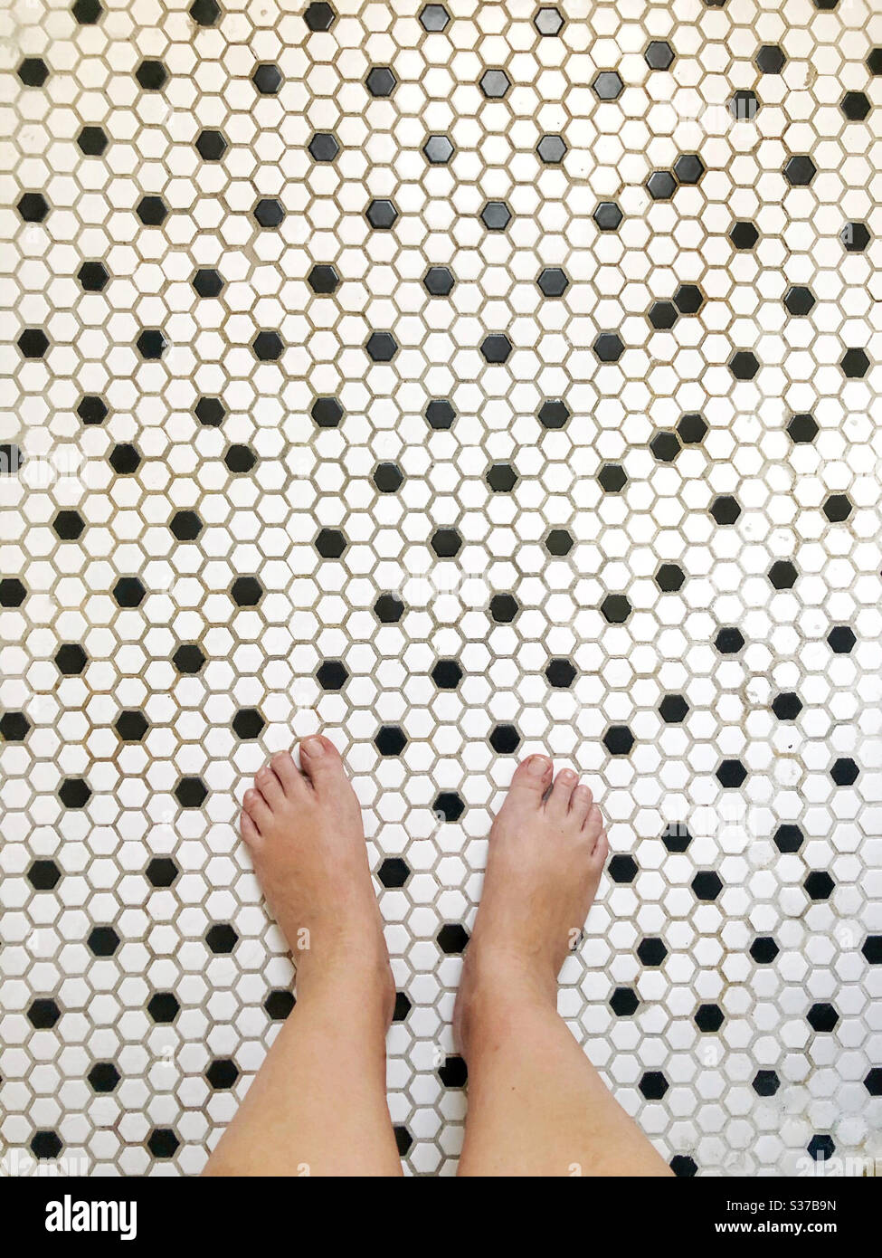 Woman standing with bare feet on old fashioned bathroom tile Stock ...