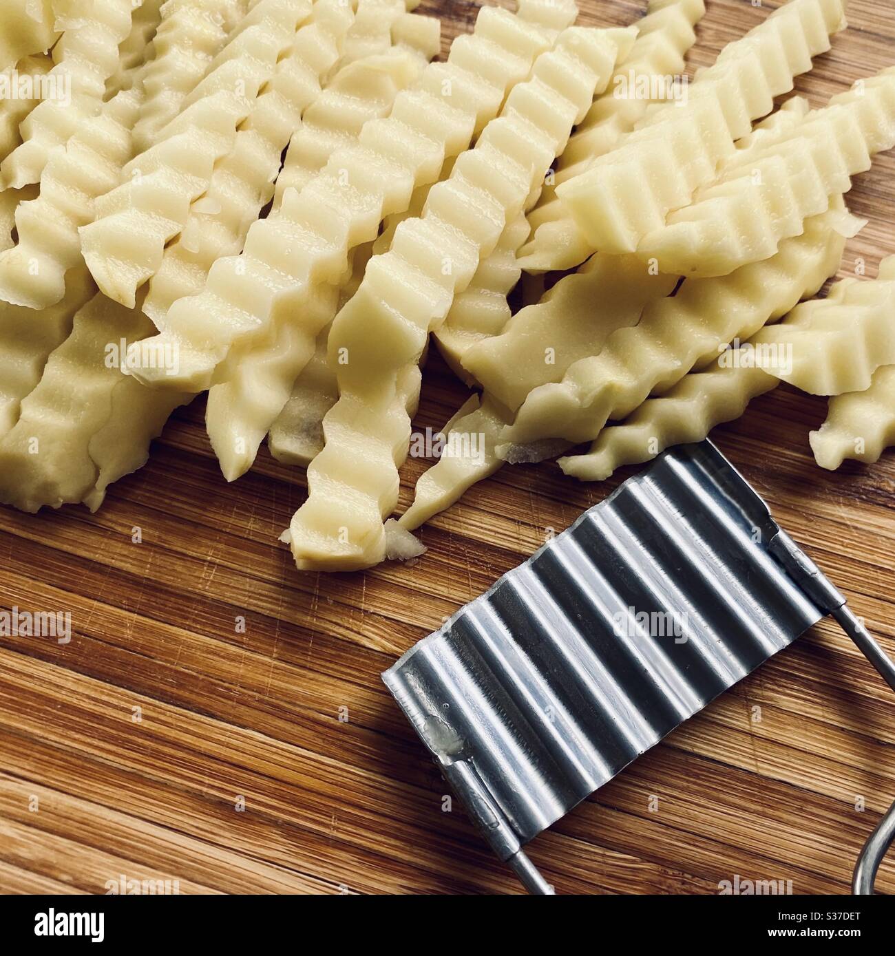 Preparing crinkle cut fries (US) or chips (UK) in the kitchen on a ...
