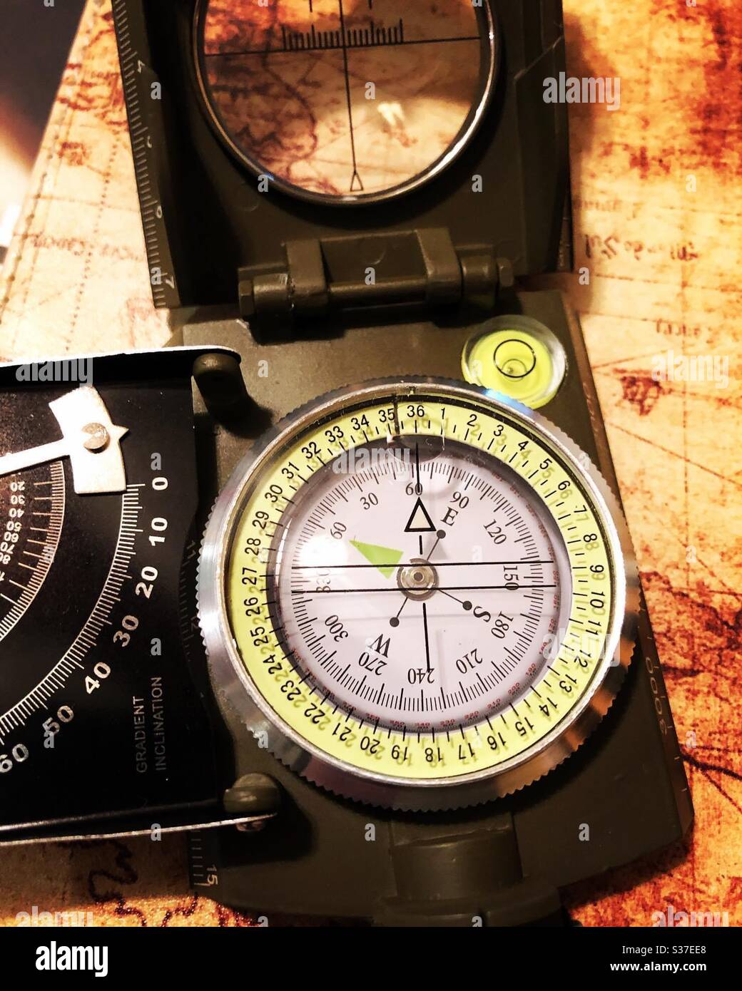 Field compass set on a antique map background Stock Photo - Alamy