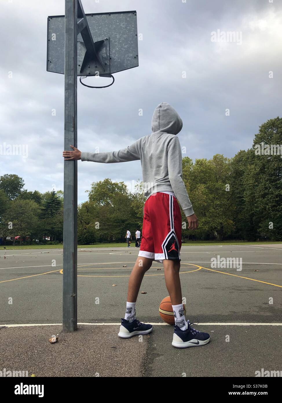 Young guy warming up to play basketball on a court in London Stock ...