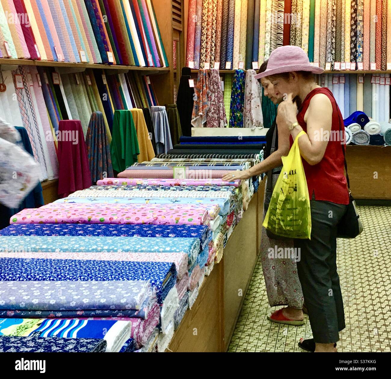 Two women shopping in a textile and fabric shop Stock Photo - Alamy