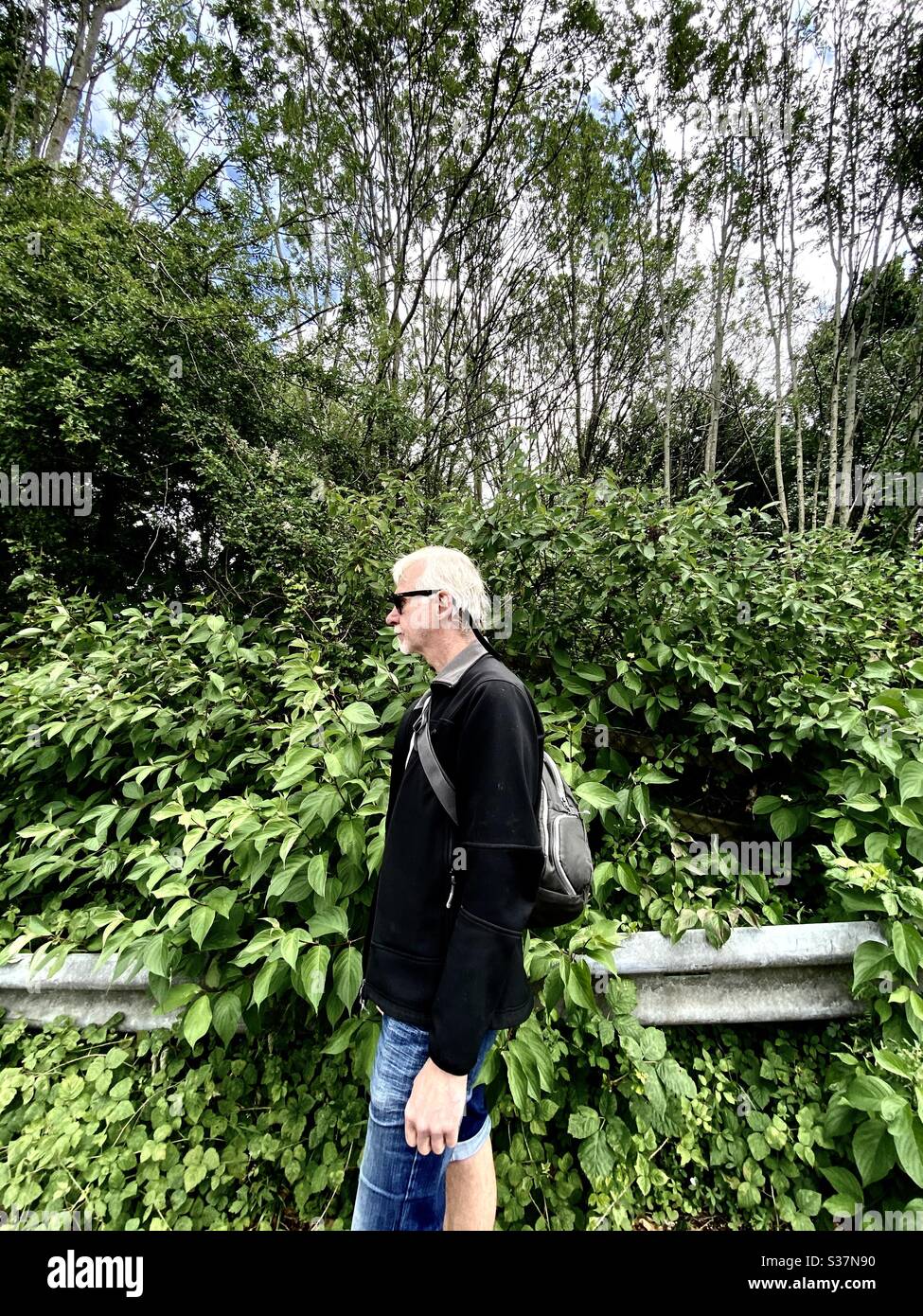 Man walking on side walk Stock Photo - Alamy