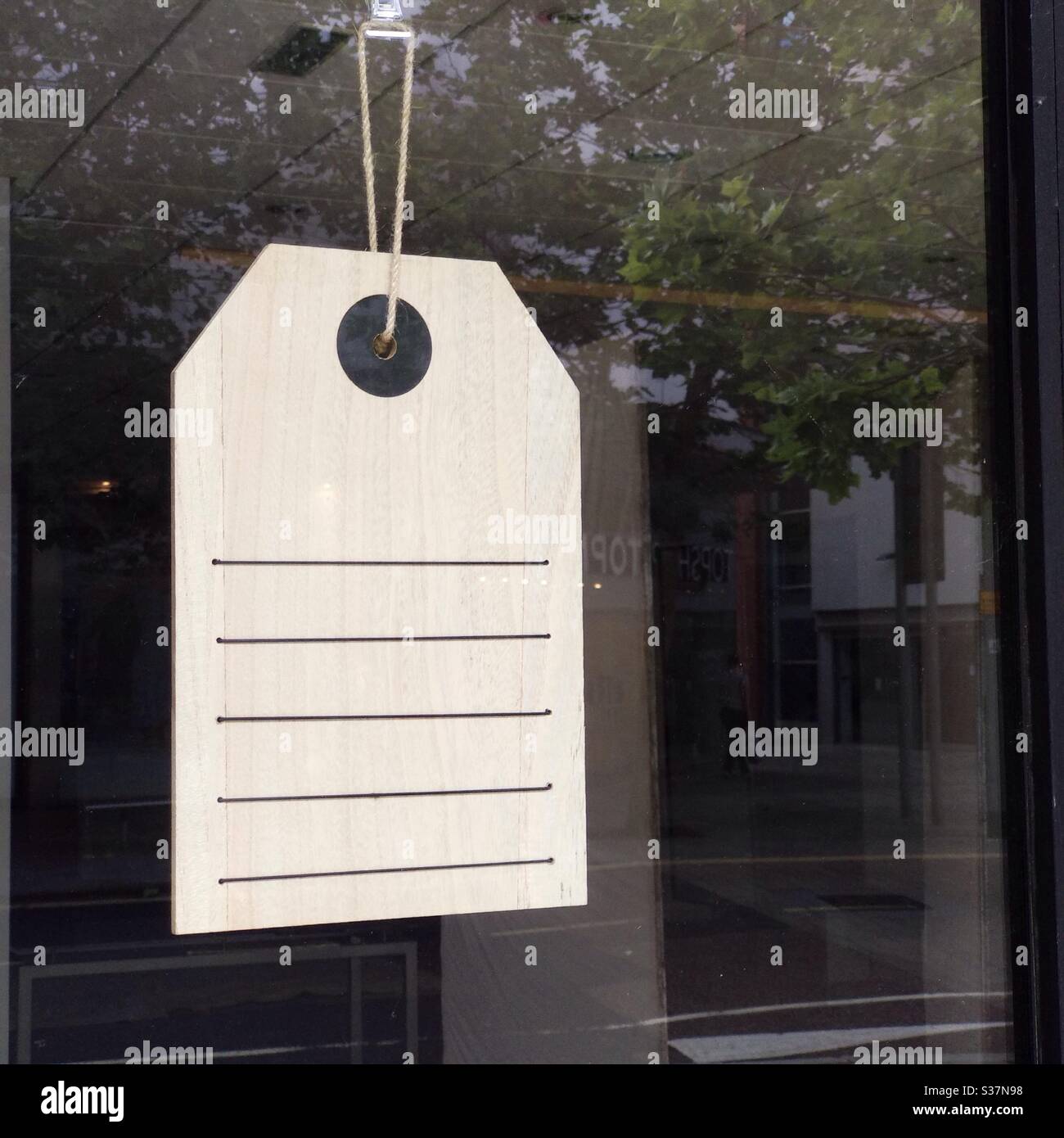 Blank tag notice hanging in shop window Stock Photo - Alamy