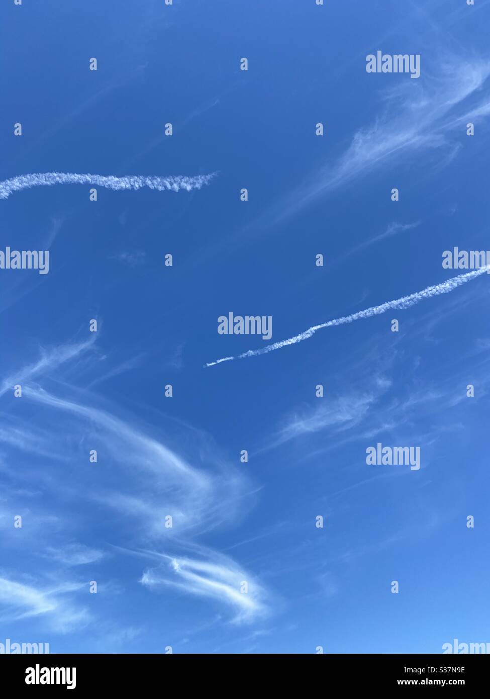 Airplane contrails against deep blue skies Stock Photo - Alamy
