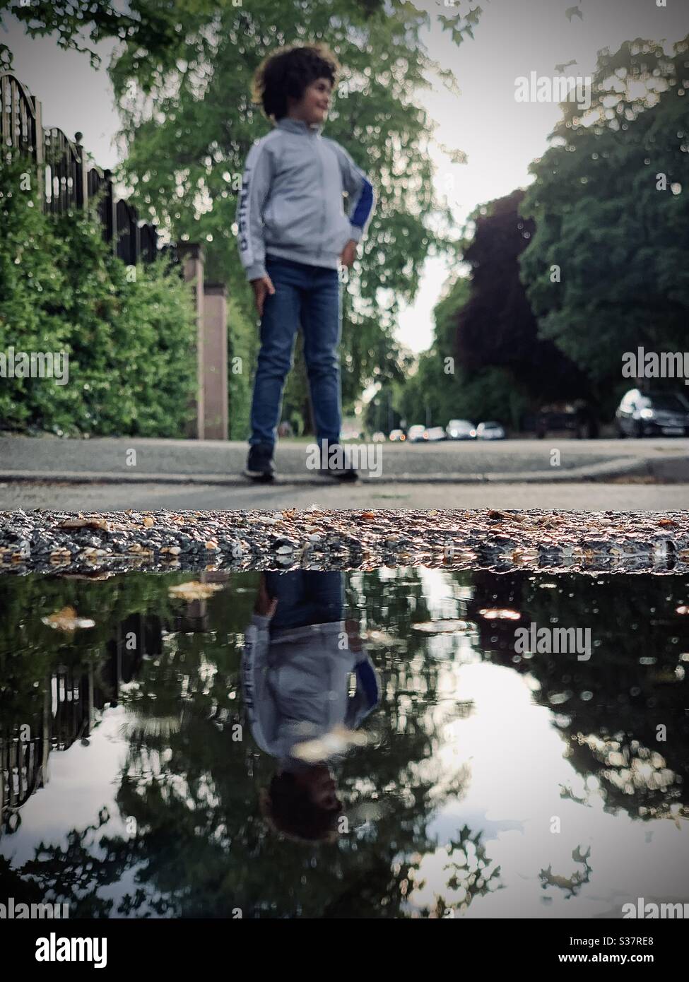 Child reflection on water in street, photographic Stock Photo - Alamy