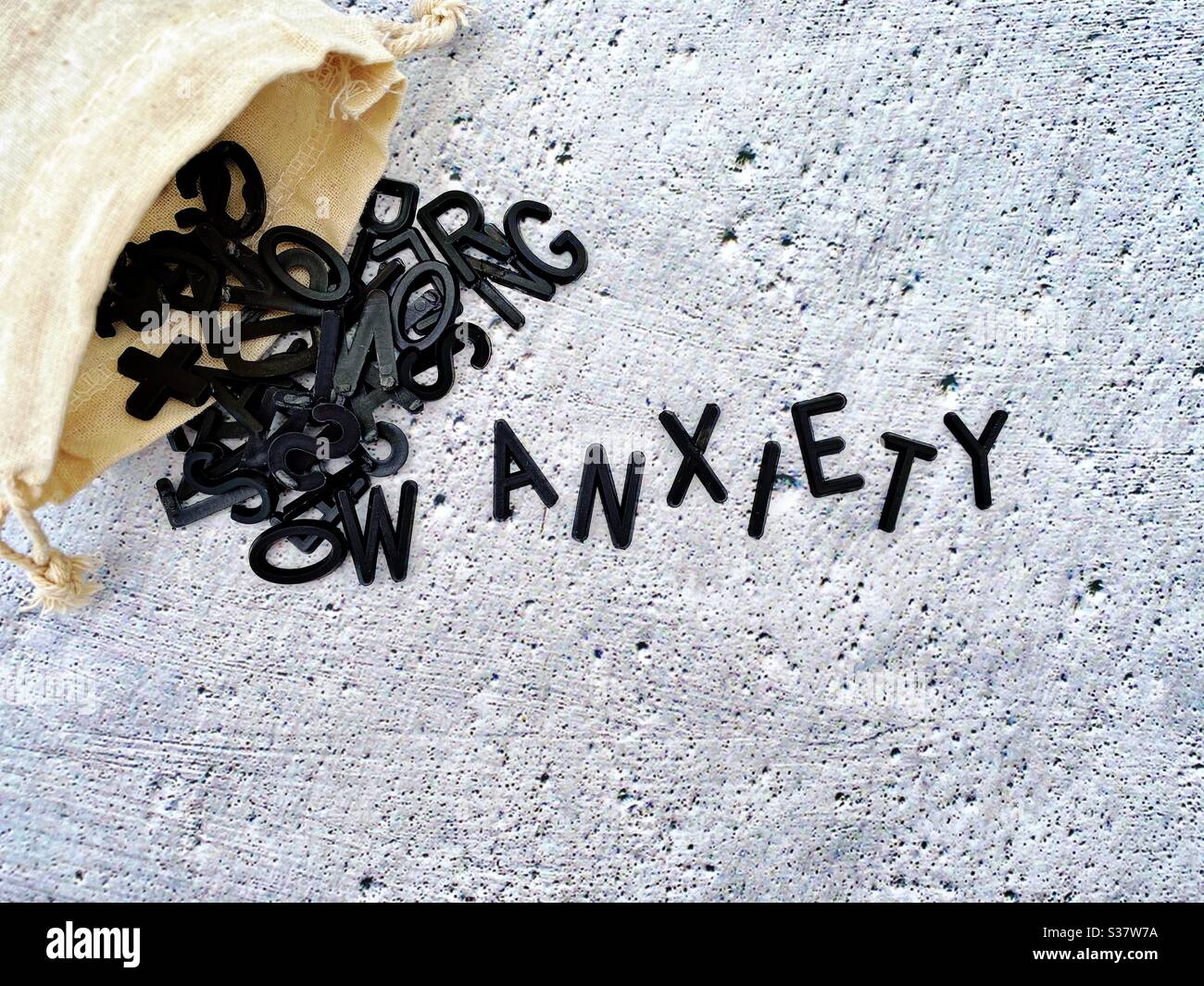 Closeup view of black letters spilling out of a small hessian bag ...