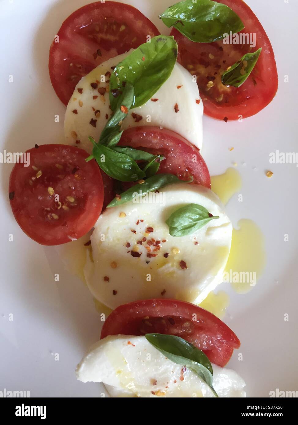 Flat lay of a salad consisting of mozzarella cheese slices, vine ...