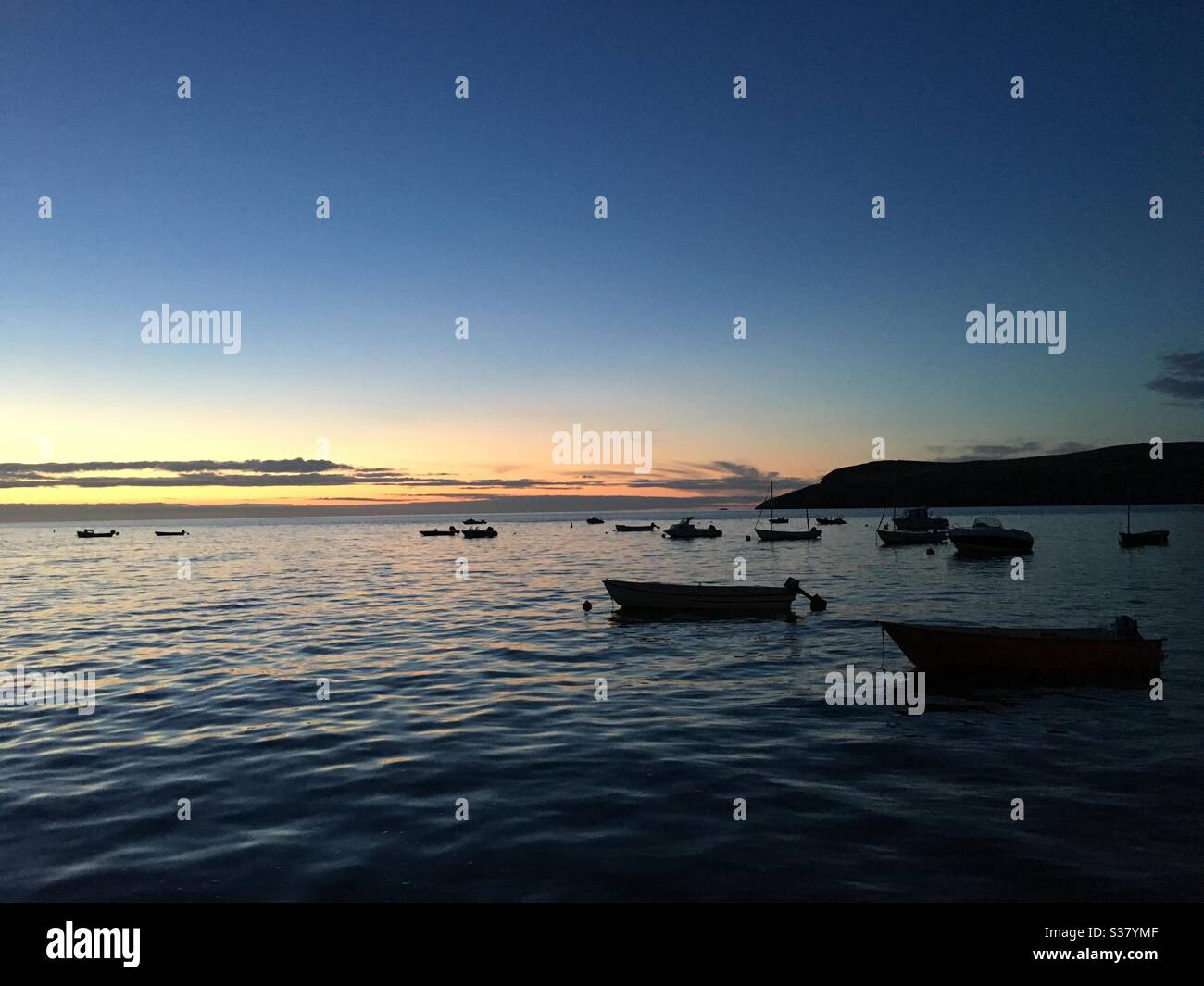 Boats bobbing on the sea in the sunset Stock Photo - Alamy