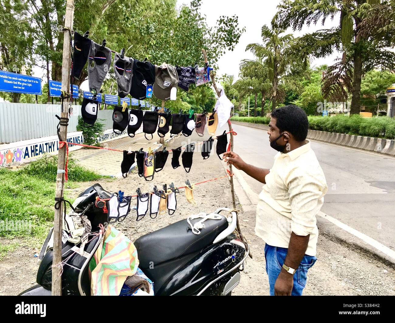 PUNE,INDIA: 13 JULY 2020: A mask seller preparing his setup on two ...